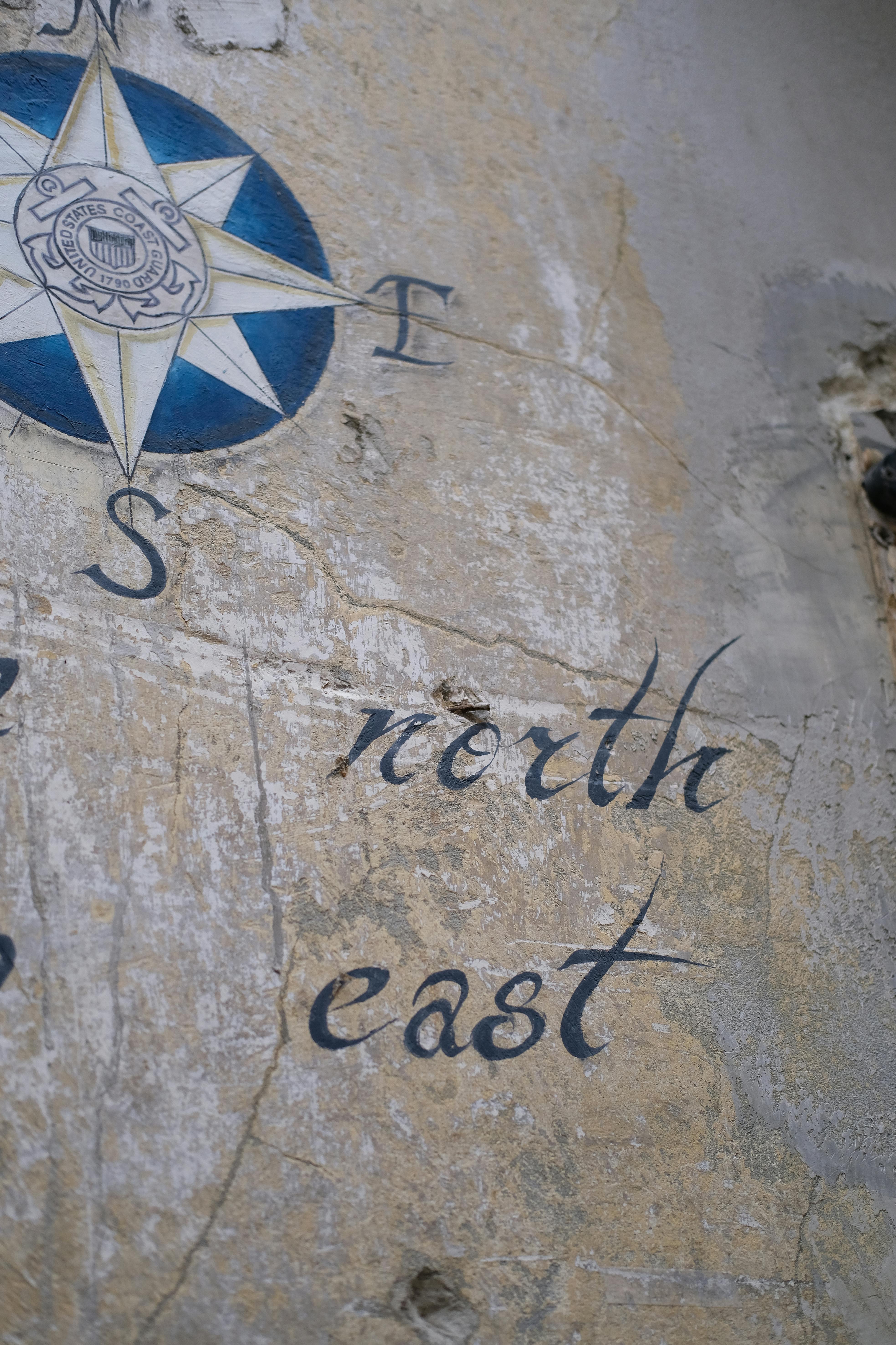 Painted Compass on Weathered Wall · Free Stock Photo