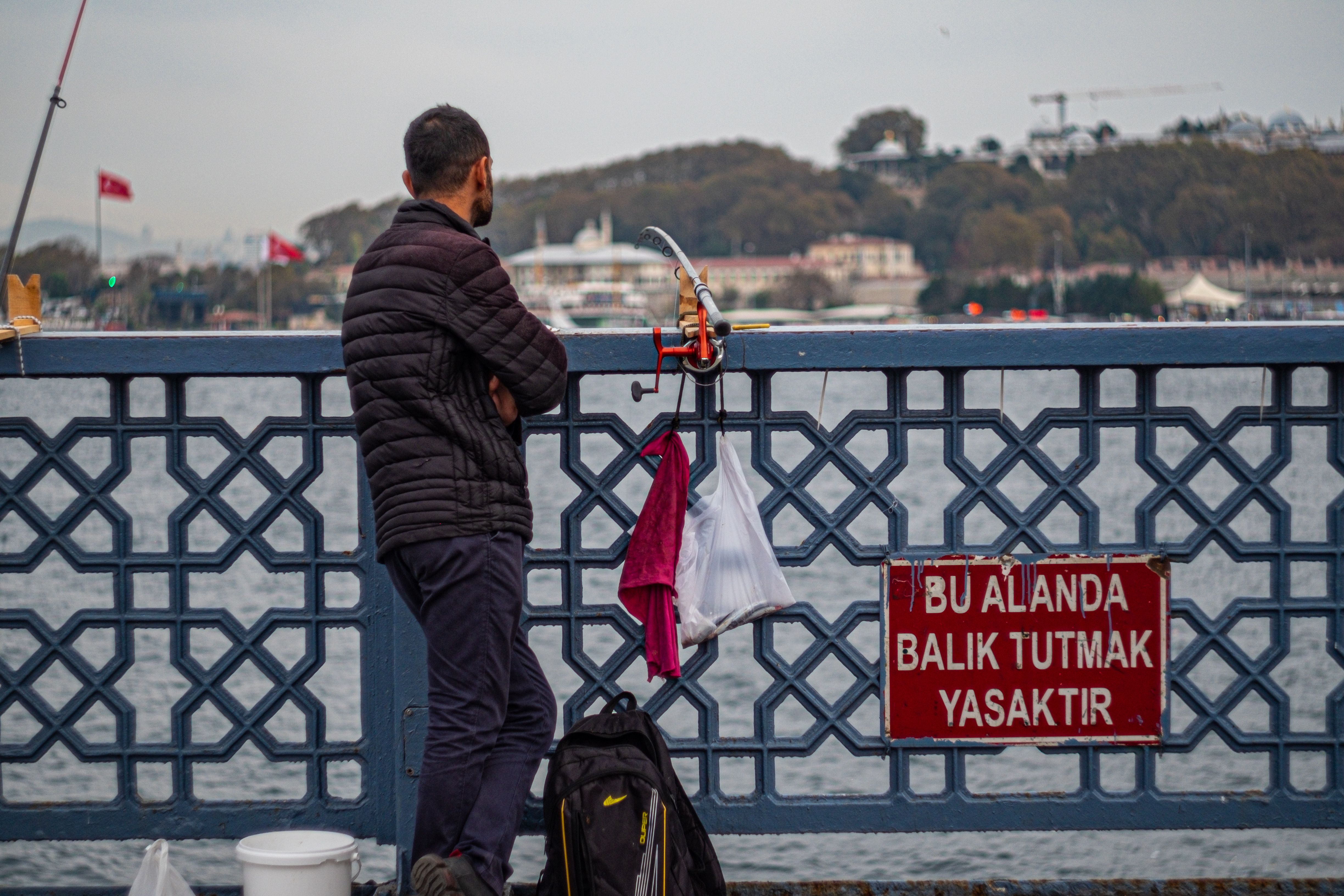 Man Fishing on a Bridge · Free Stock Photo