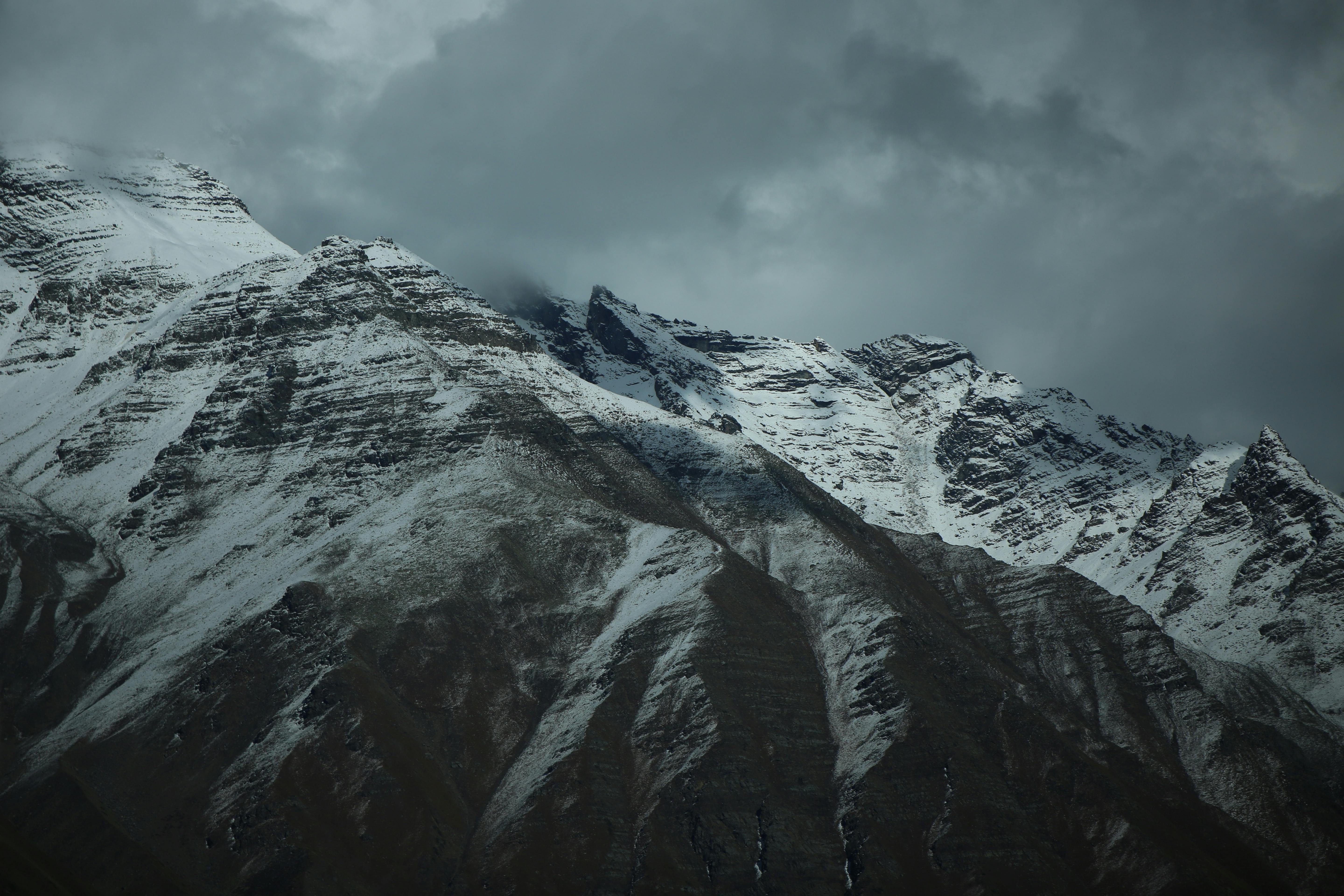 A Snow Covered Mountain under a Gloomy Sky · Free Stock Photo