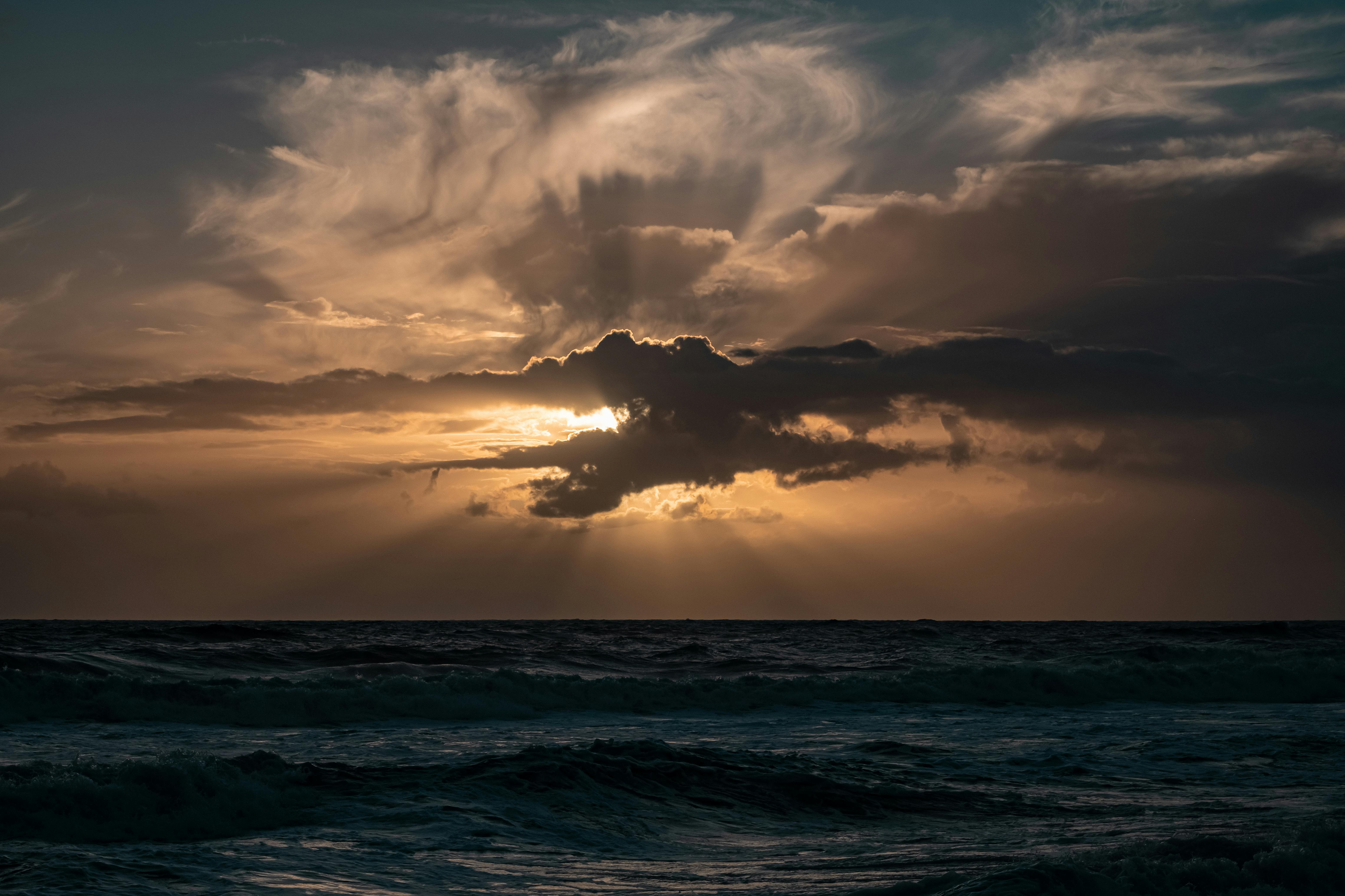 Sunset Behind Dark Clouds over Sea · Free Stock Photo