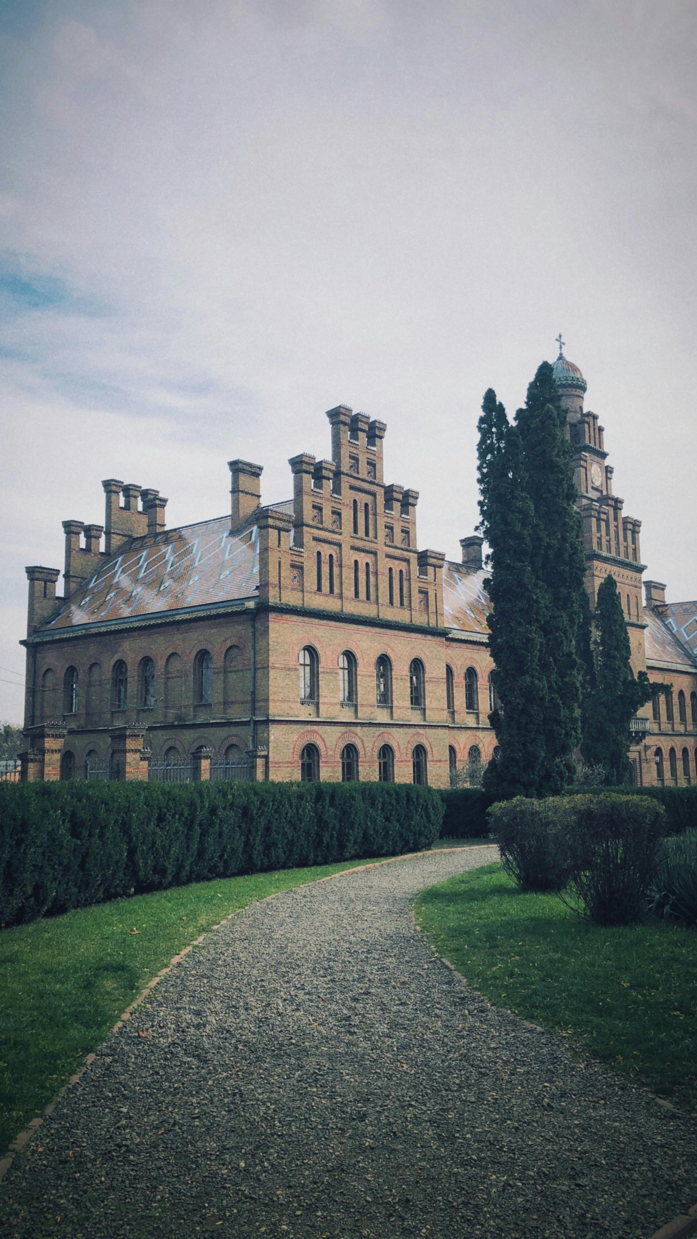 Brown Concrete Building Near Green Grass Field · Free Stock Photo