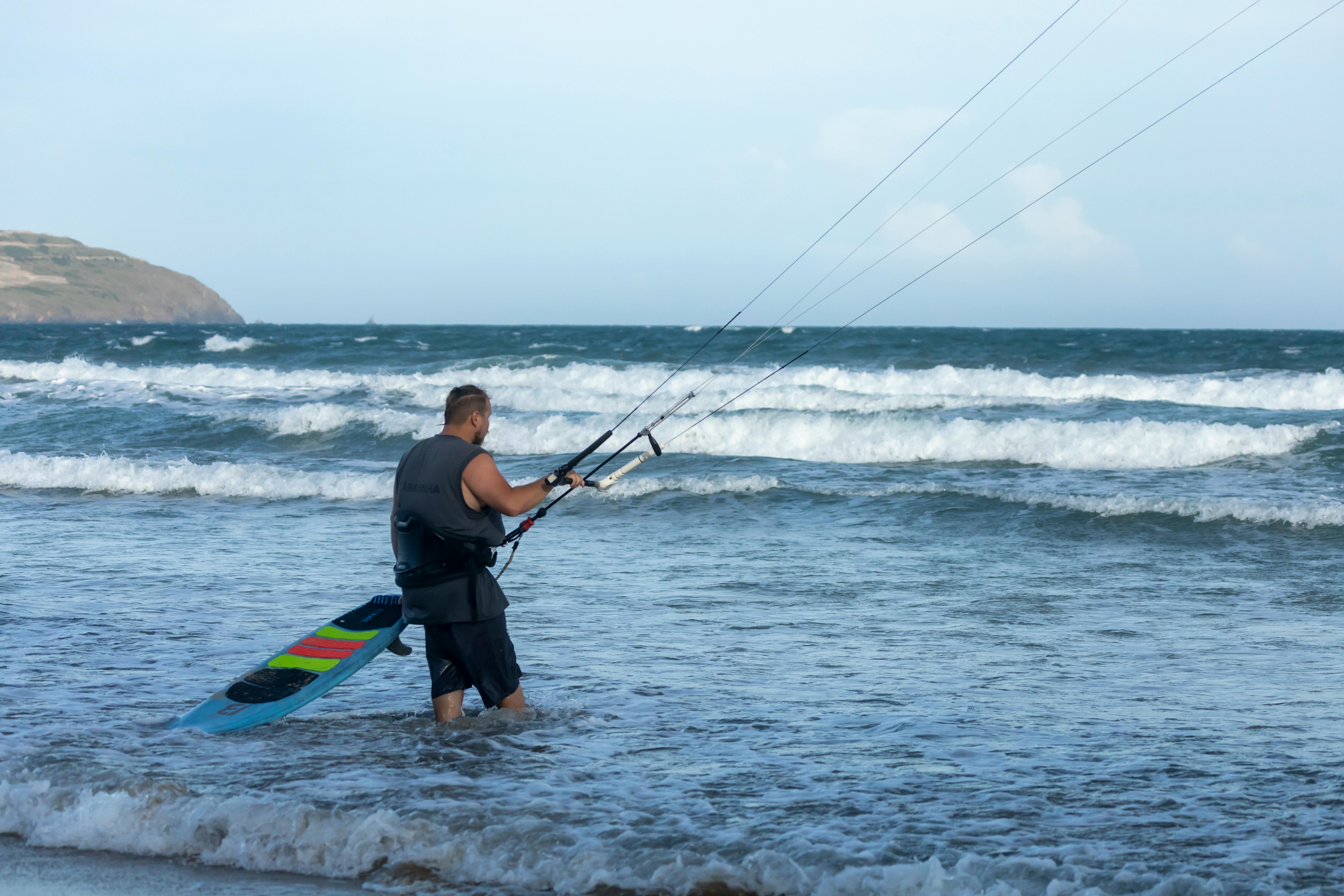 Man Walking into Sea with Wakeboard · Free Stock Photo