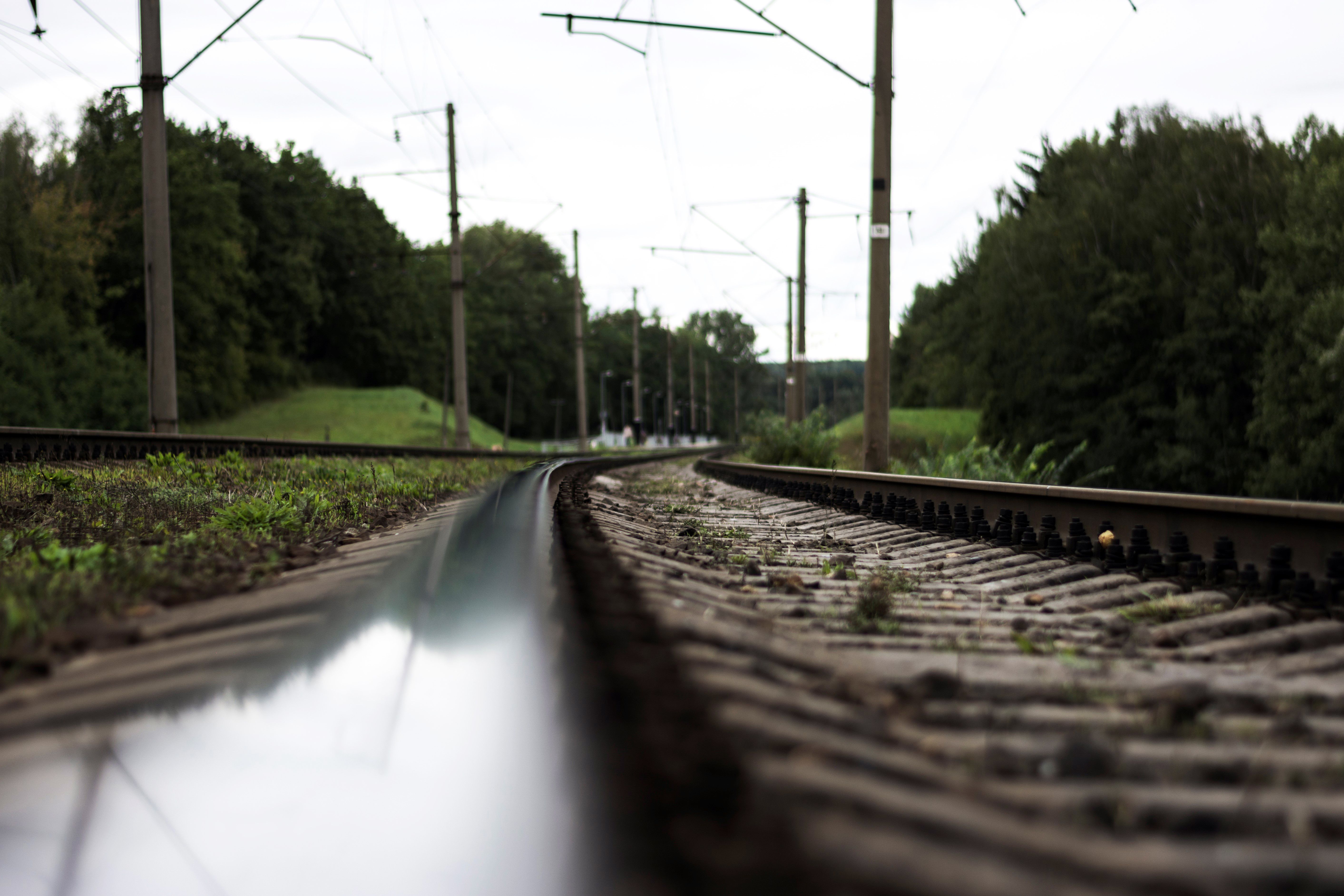 Photo of Woman in Black Outfit Squat Posing in Middle of Train Track ...