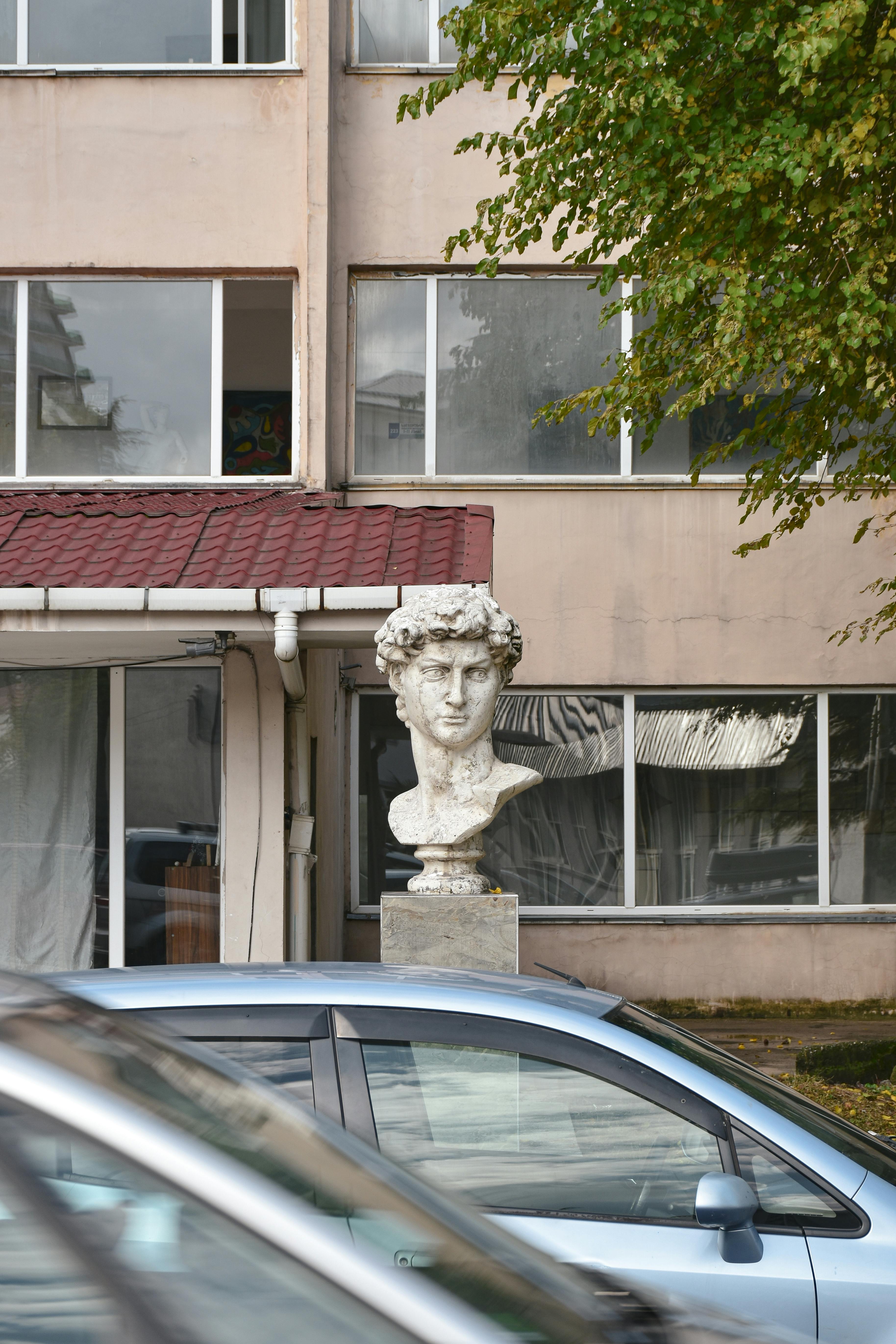 A Gypsum Head Near Cars · Free Stock Photo