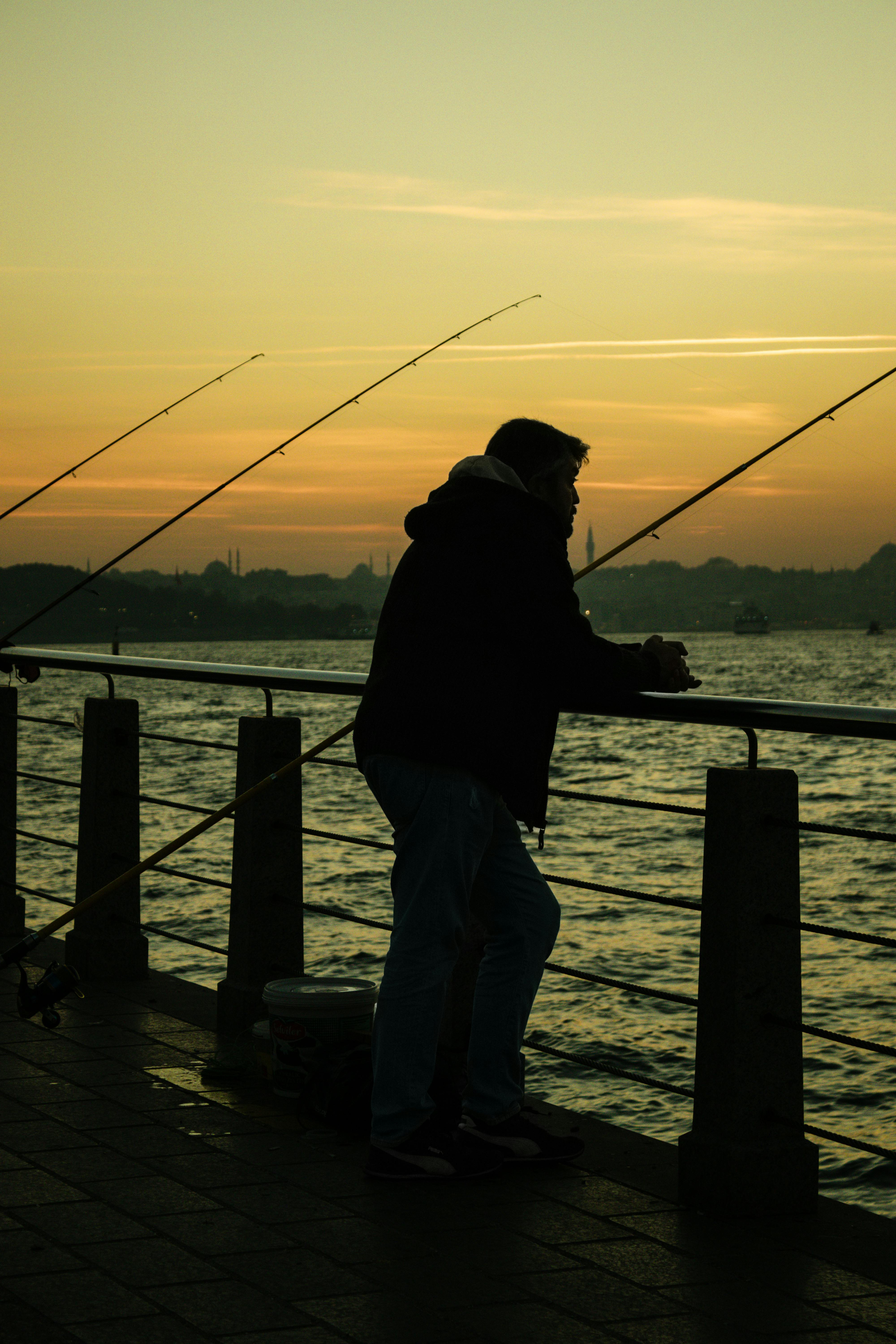A Man Wearing a Black Jacket Standing on a Wooden Dock with Metal ...