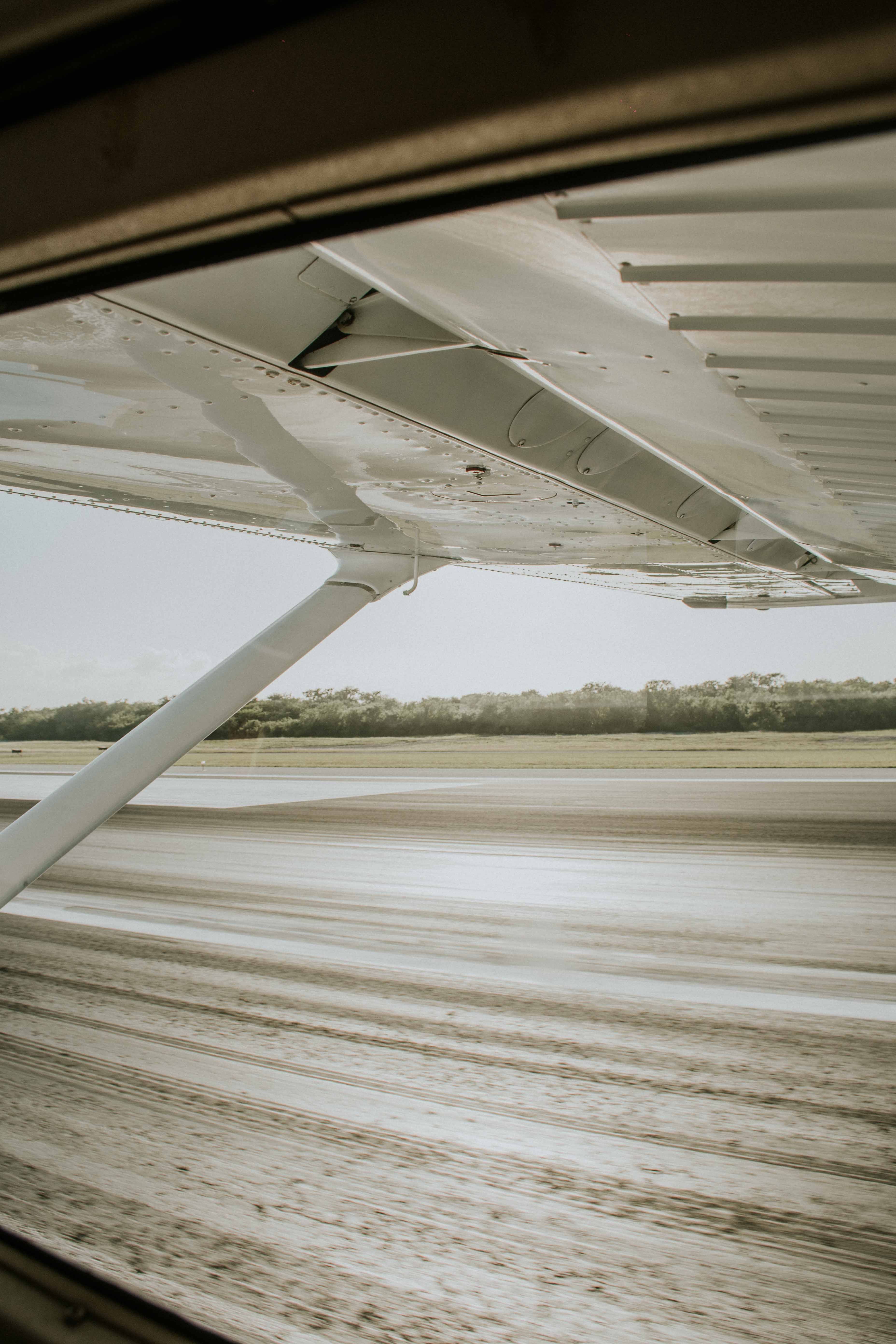 Airplane Wing over Tarmac · Free Stock Photo