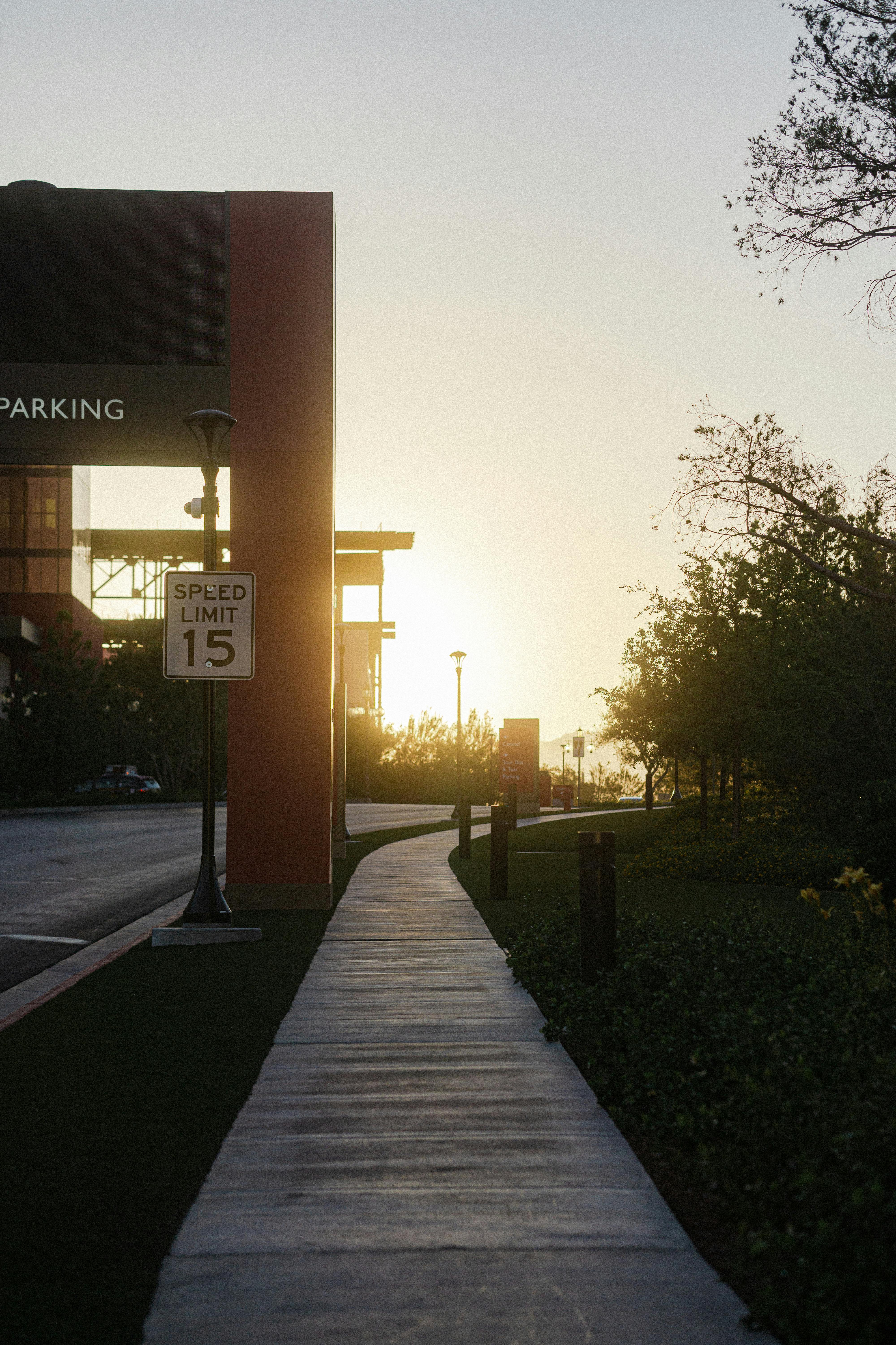 Sidewalk by an Entrance to a Parking Lot at Sunset · Free Stock Photo