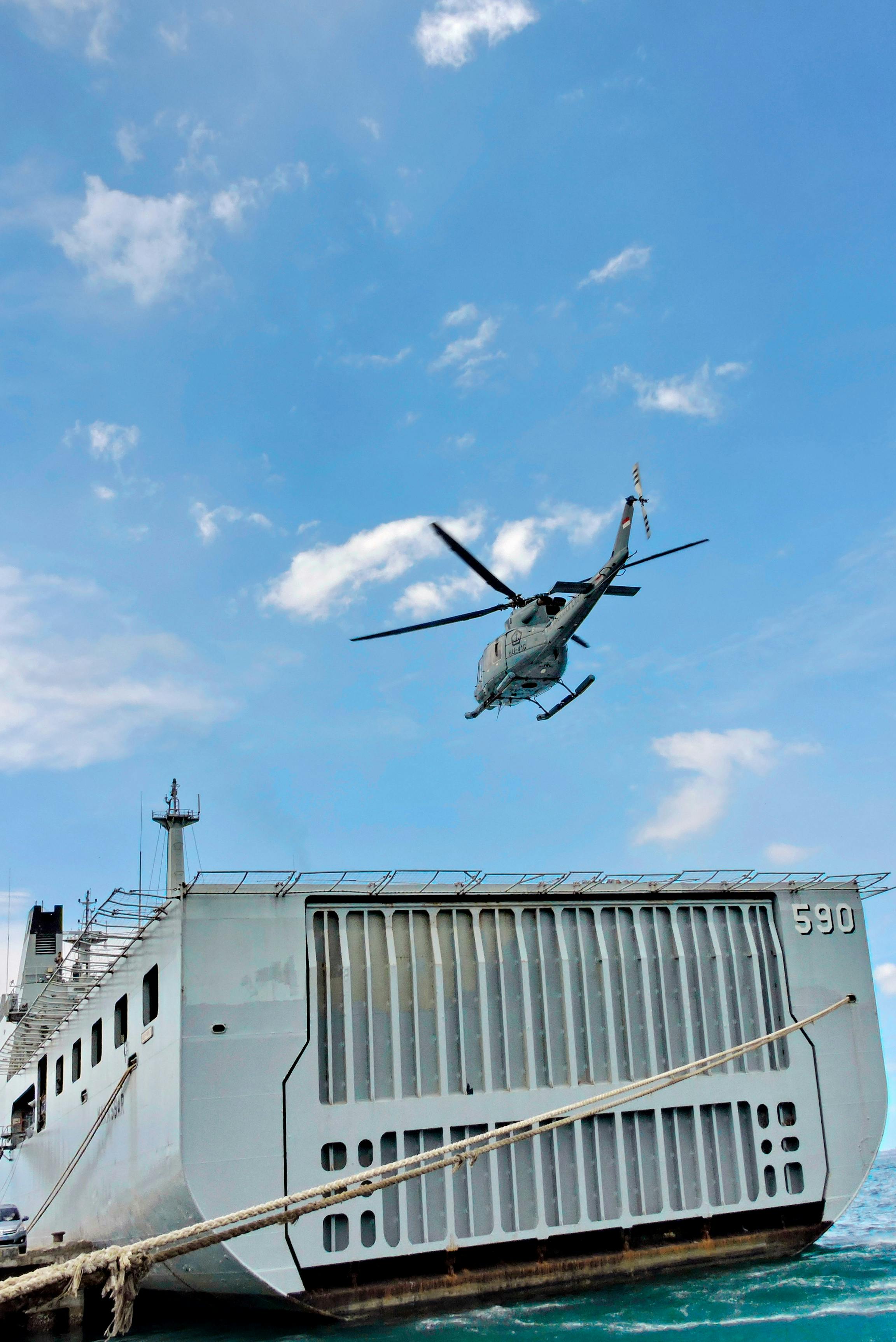 Helicopter Flying over Moored Ship · Free Stock Photo