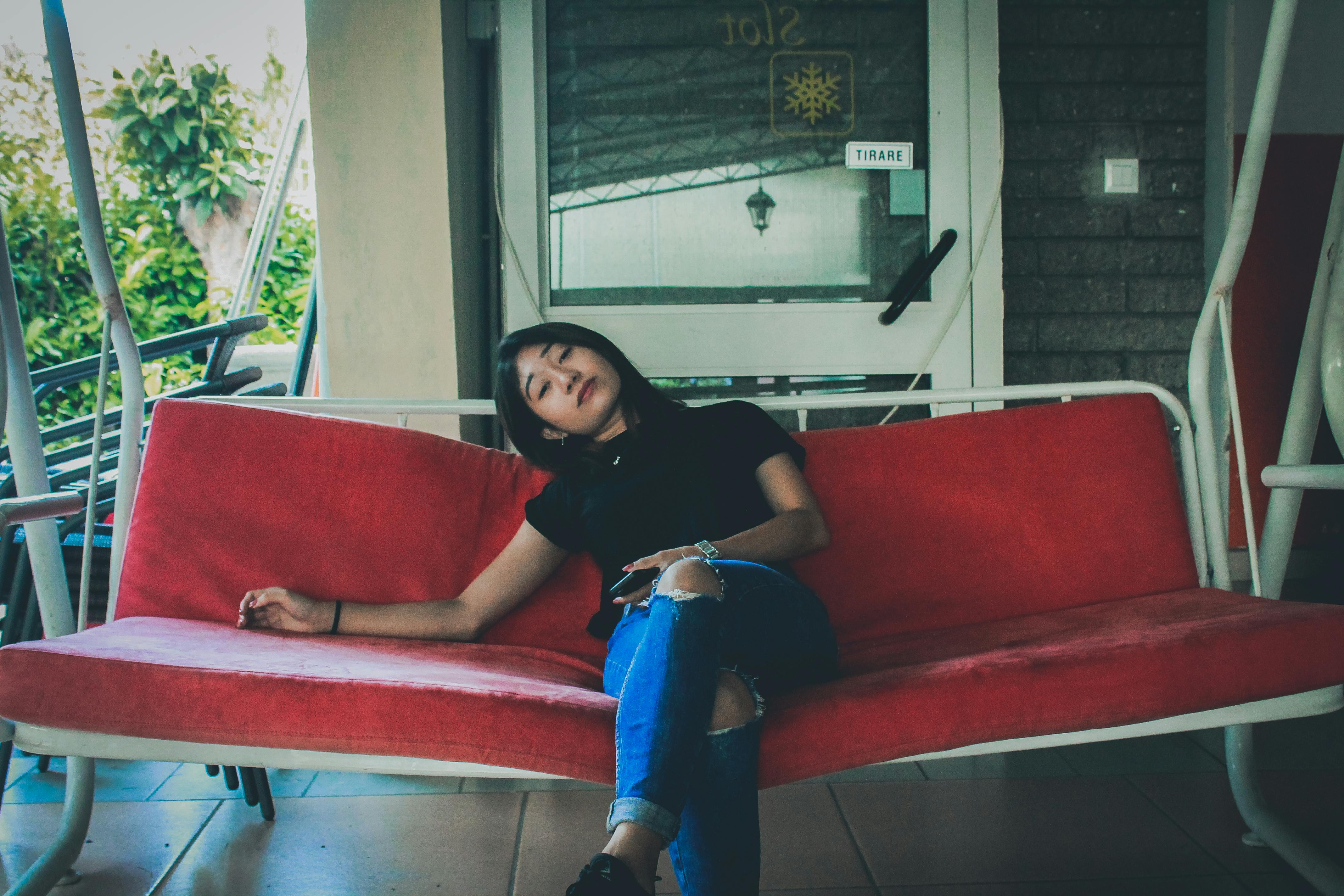 Woman Sitting on Red Hanging Bench · Free Stock Photo