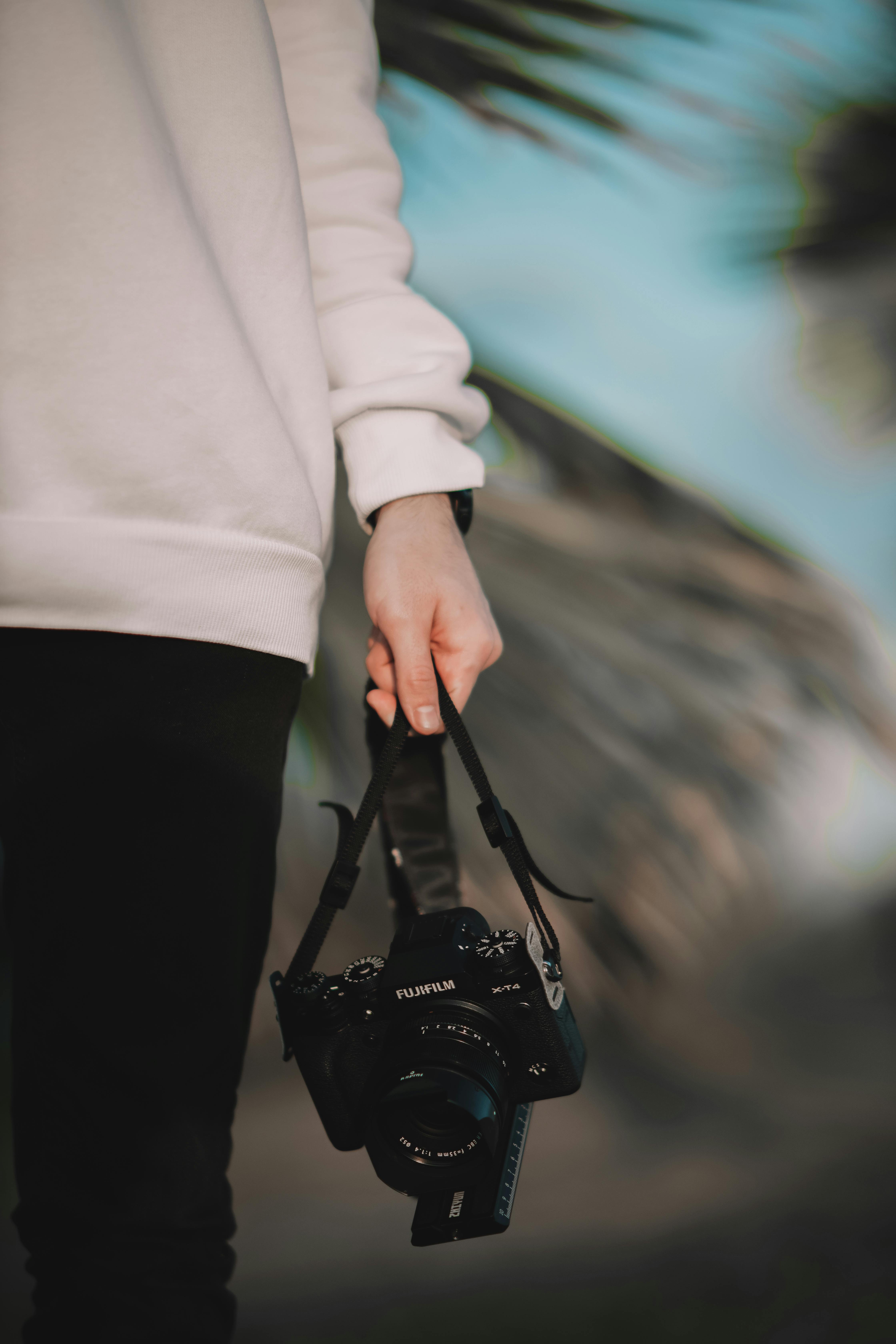 A Person Holding Black DSLR Camera · Free Stock Photo