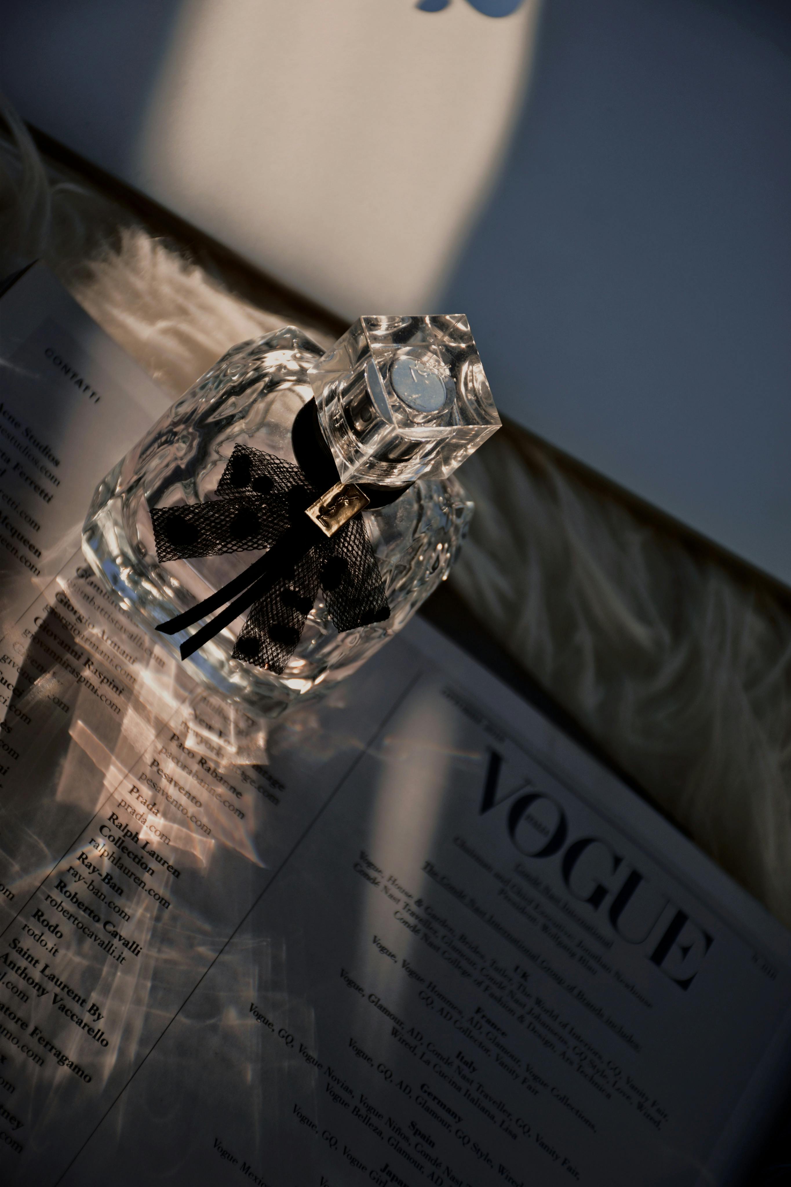Bottle of Perfume on Top of a Magazine · Free Stock Photo