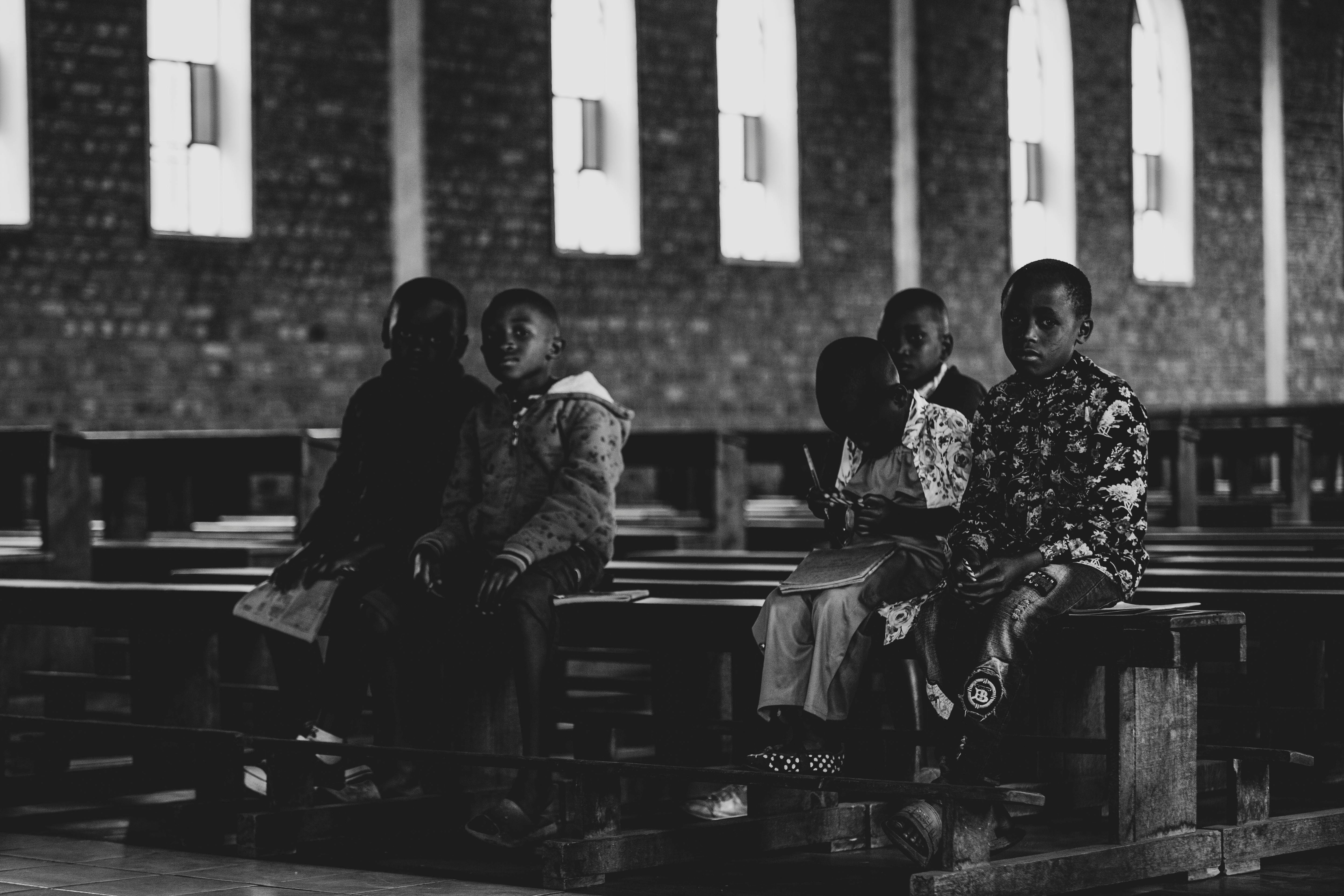 A Grayscale of Children Sitting on a Wooden Bench · Free Stock Photo