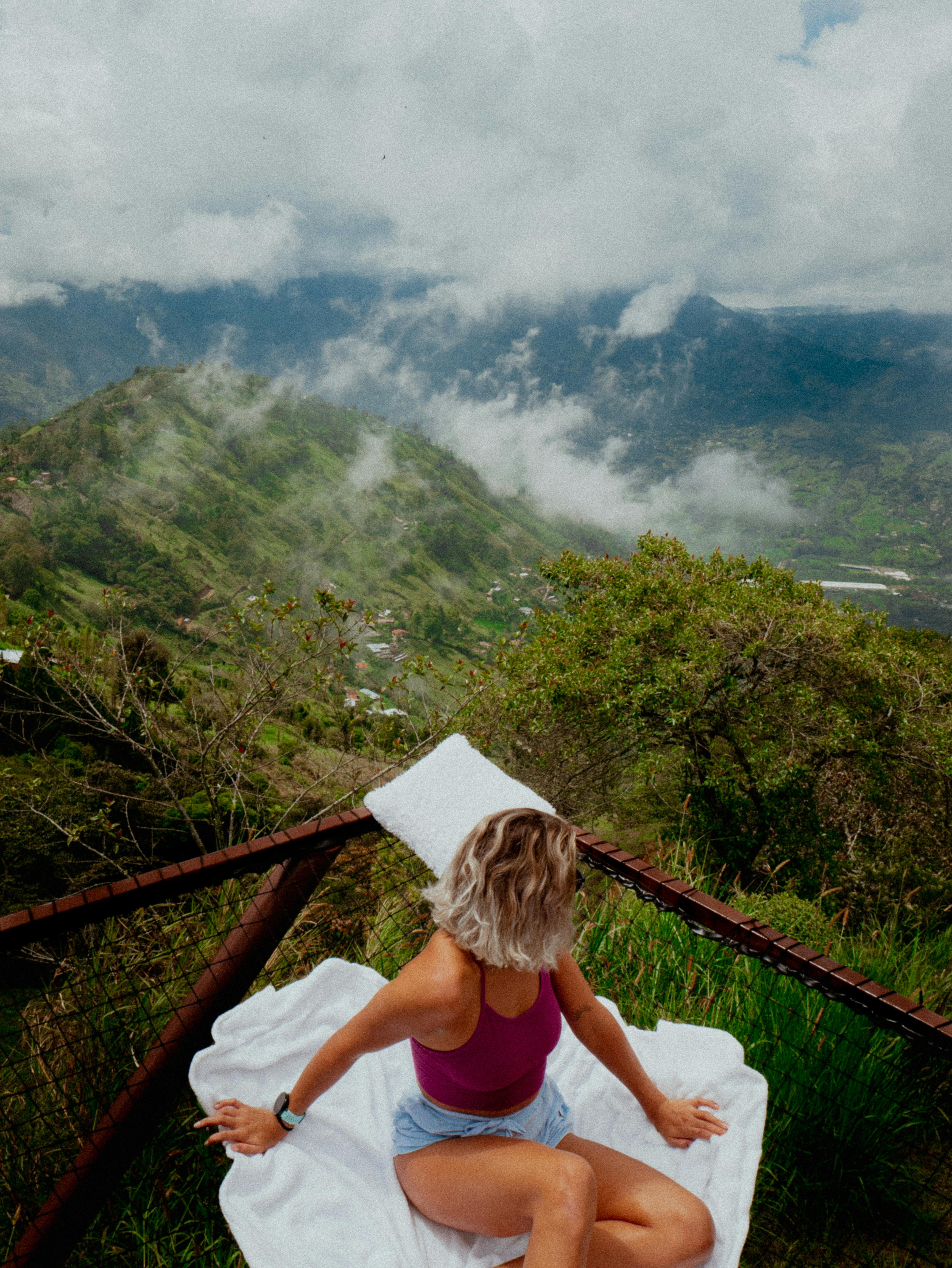 Blonde Woman Sitting over Hills and Valley · Free Stock Photo
