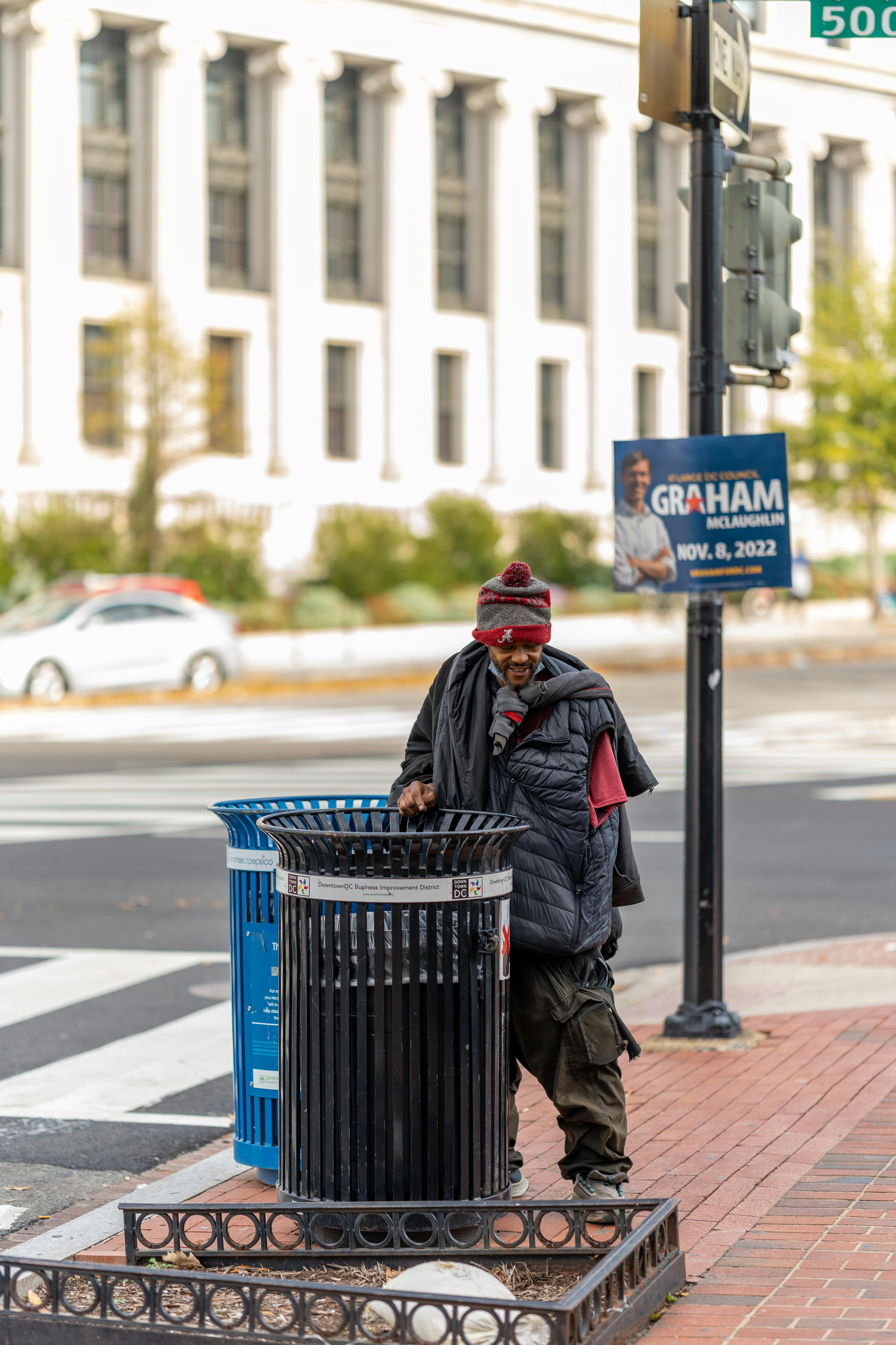 A Man Standing Beside the Trash Bin · Free Stock Photo