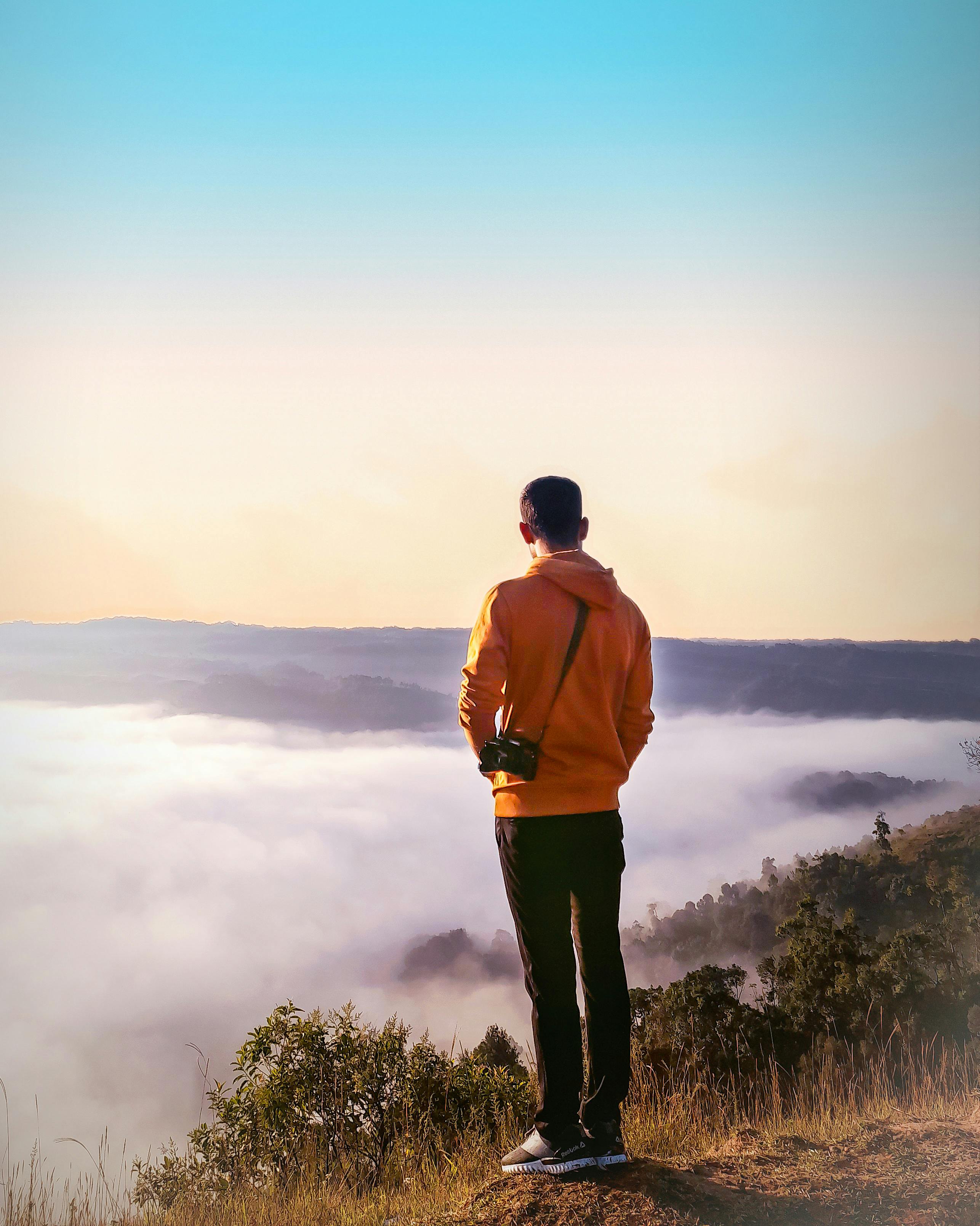 Person Standing on Grass Field Looking at the View · Free Stock Photo