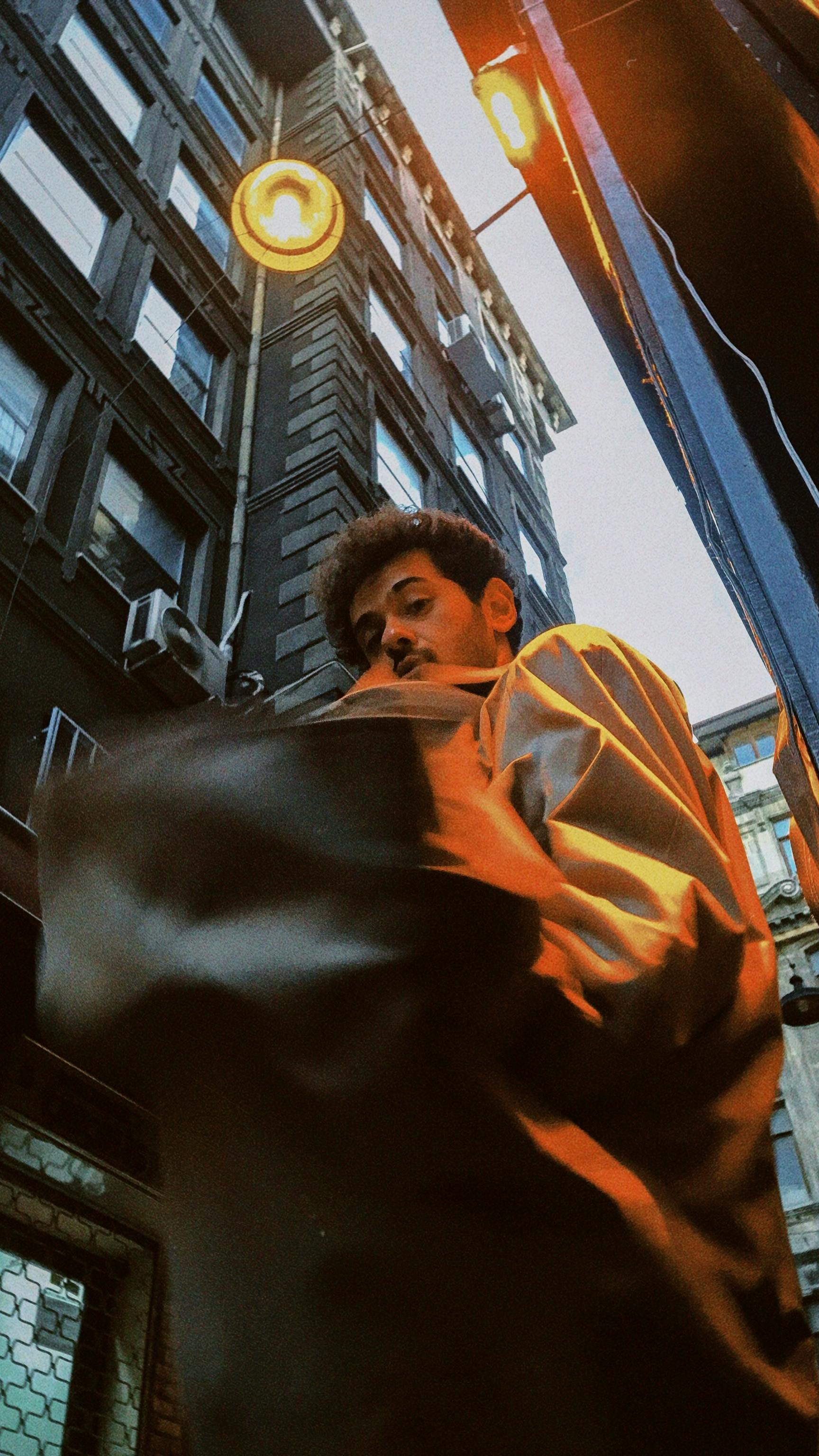 Low-Angle Shot of a Man in an Olive Jacket Taking a Step · Free Stock Photo