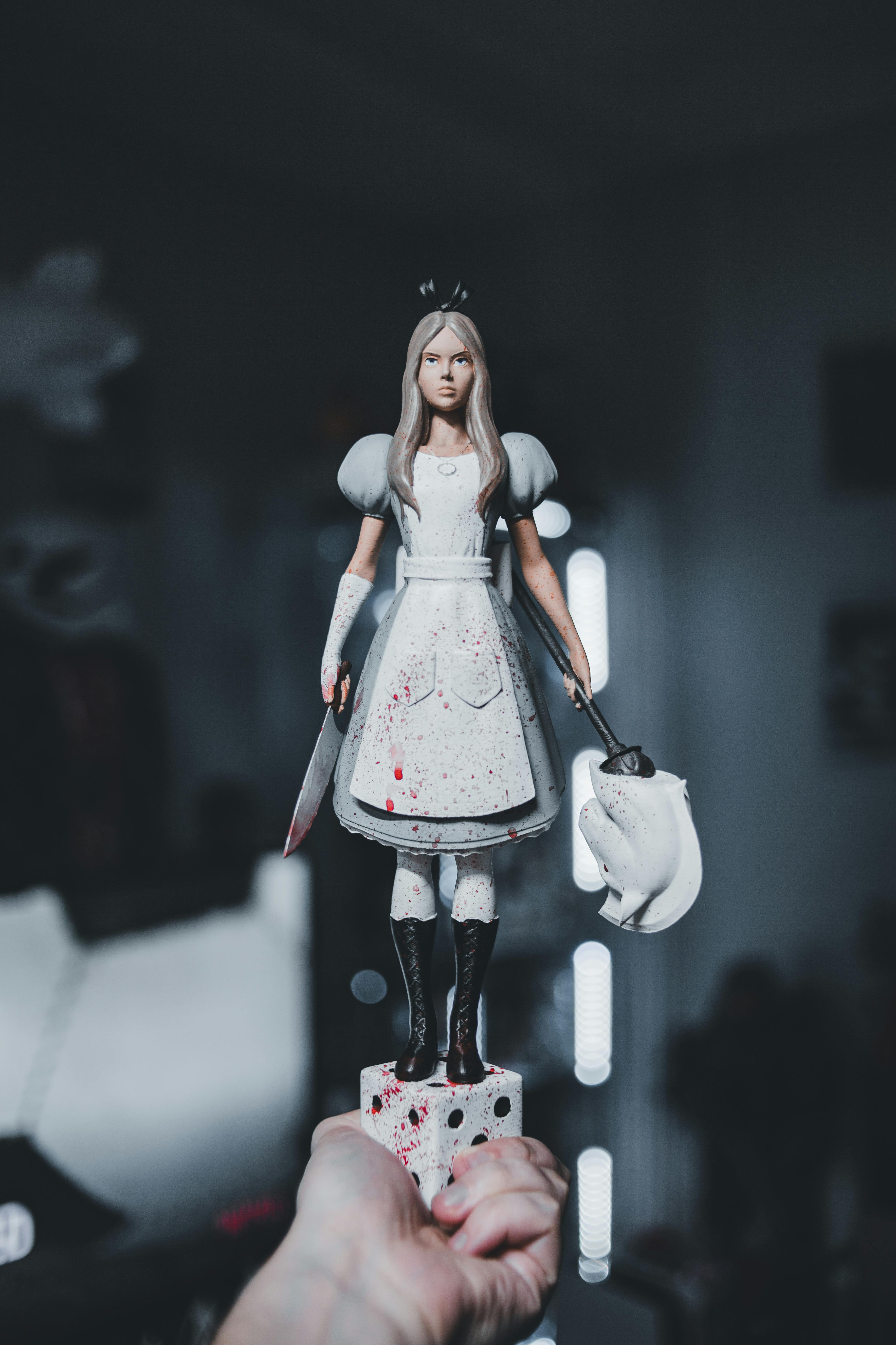 Person Holding an Alice Figure · Free Stock Photo