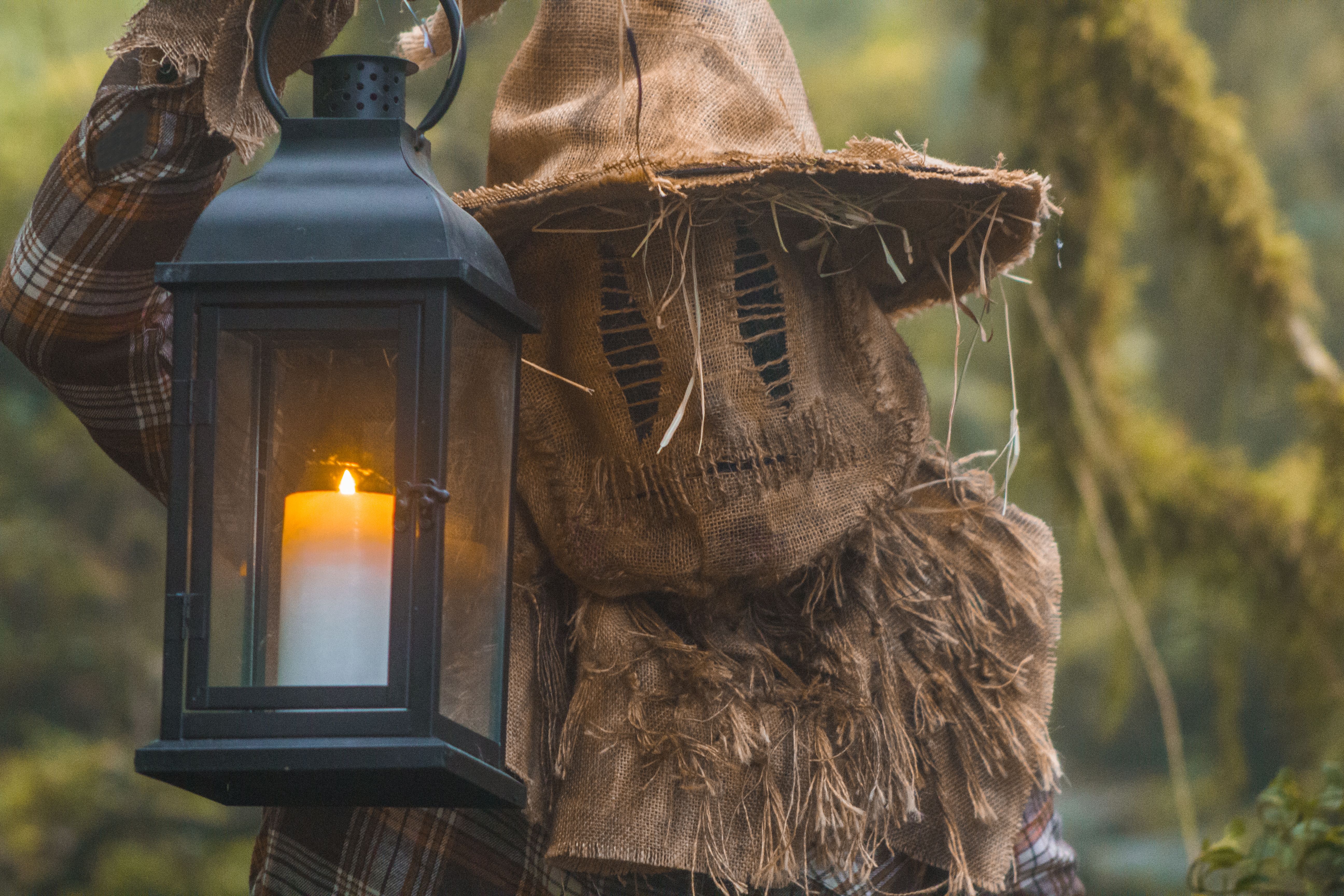 Person in Scarecrow Costume Standing in Eerie Forest with Lantern ...