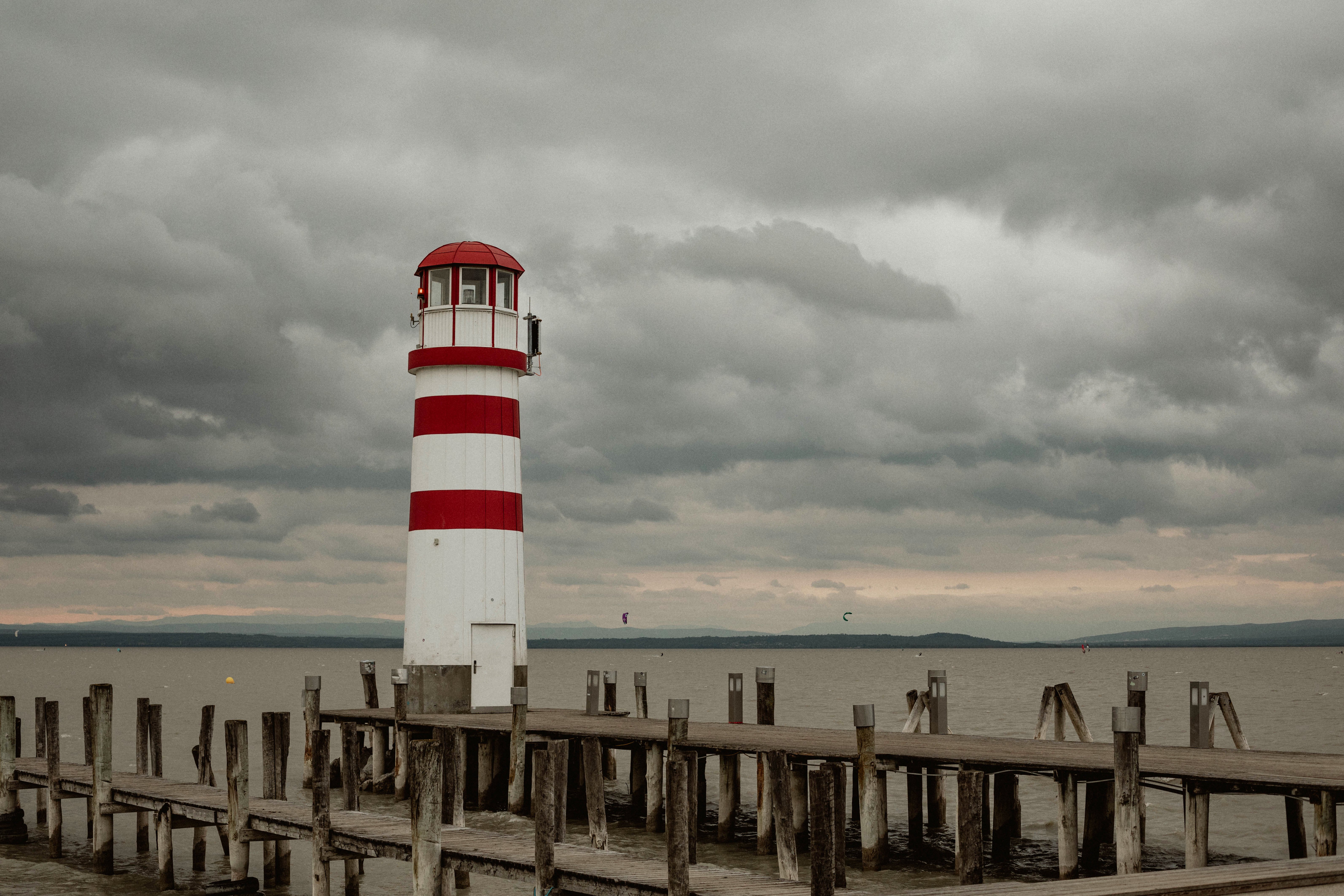 White and Red Lighthouse on Wooden Dock under the Cloudy Sky · Free ...