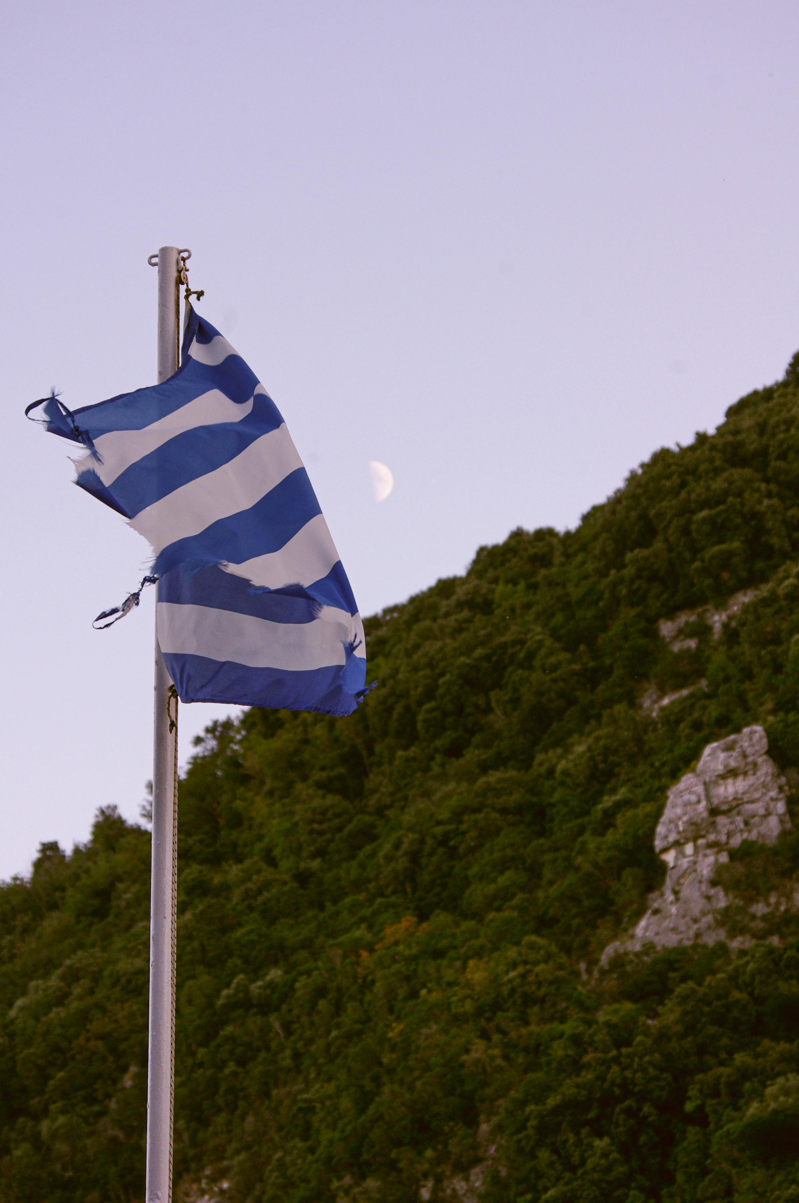 Greek Flag Fluttering Outdoors at Dusk · Free Stock Photo