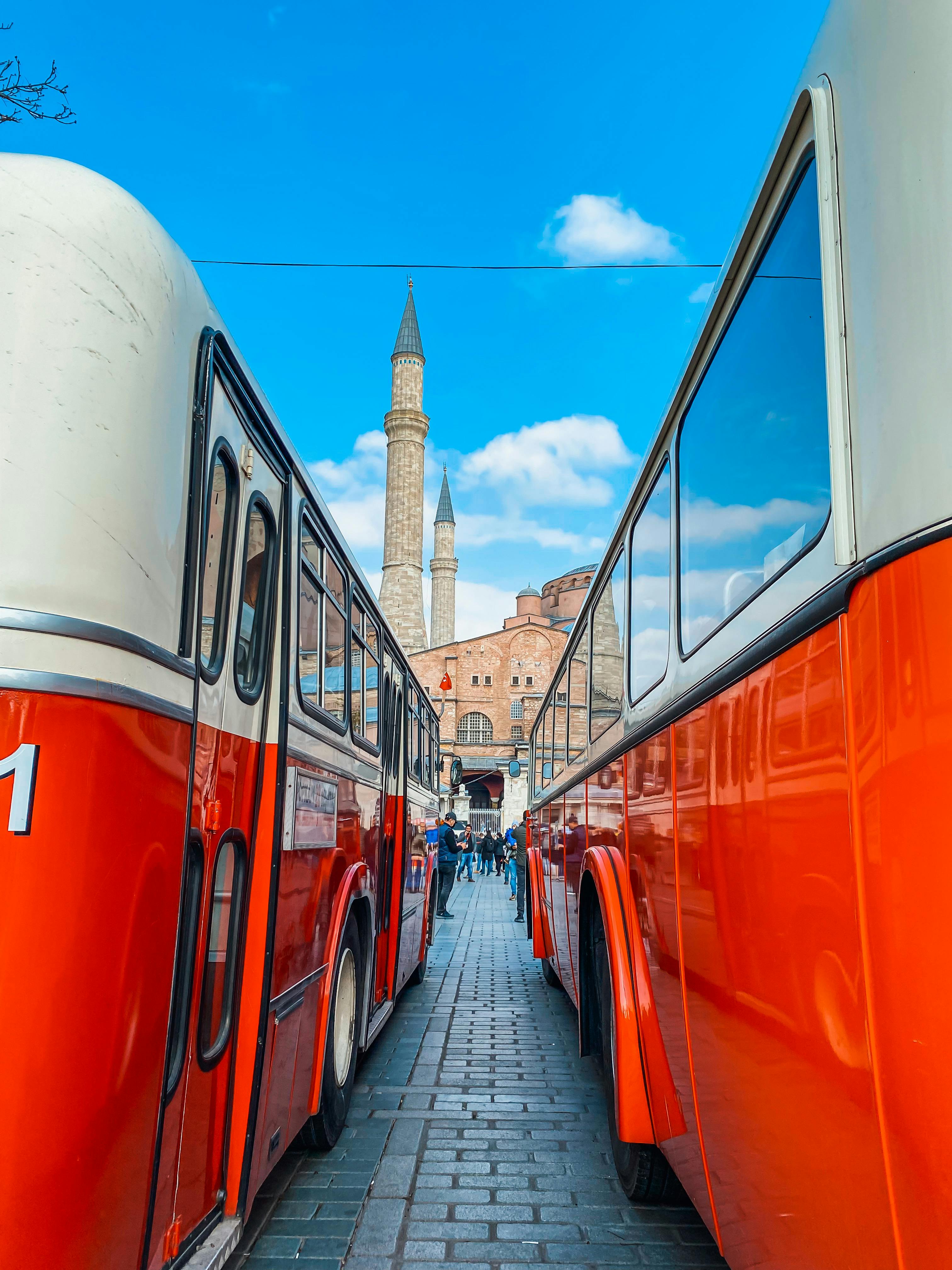 Orange and White Buses Near Minarets · Free Stock Photo