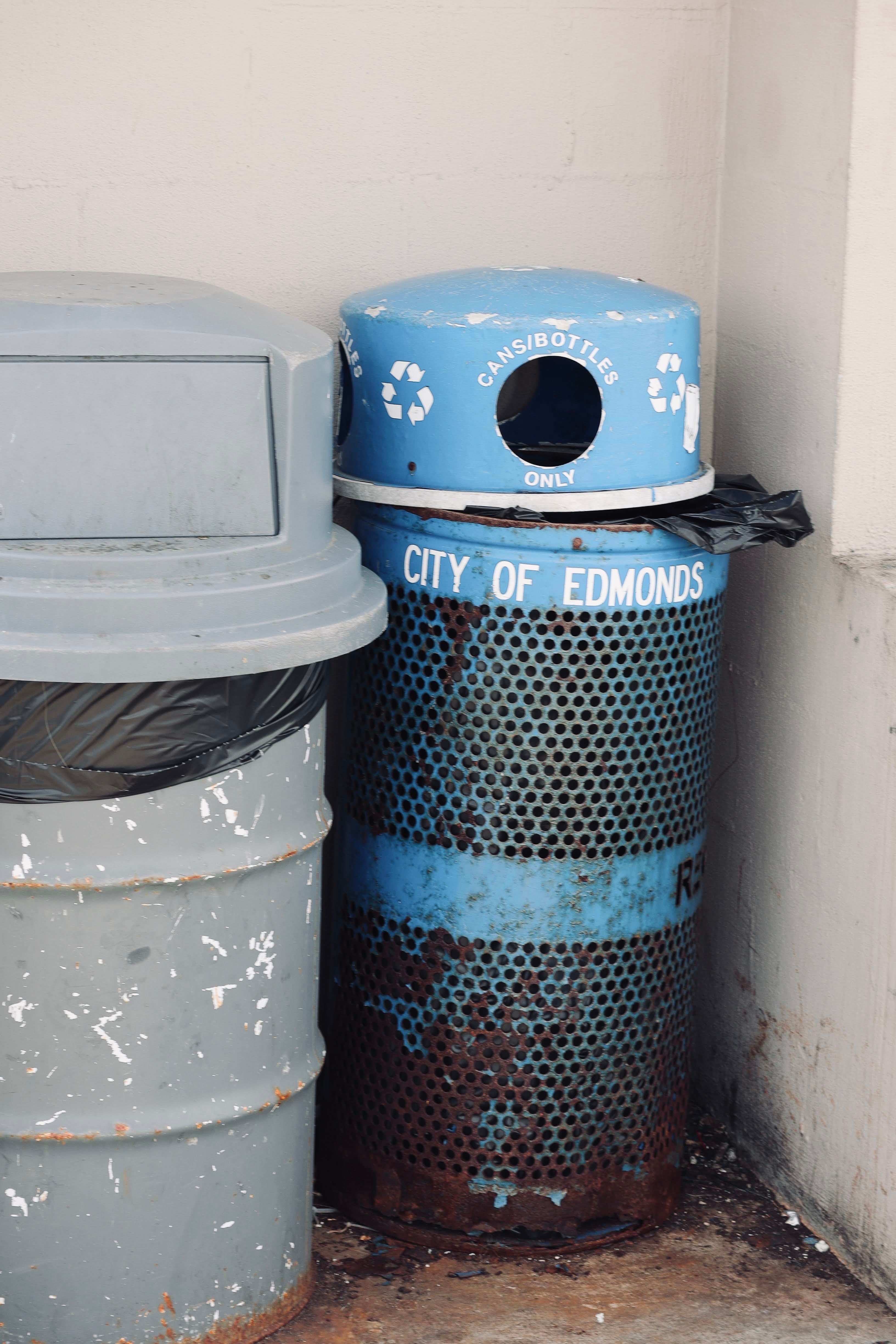 A Row of Large Trash Bins Near the Brick Wall · Free Stock Photo