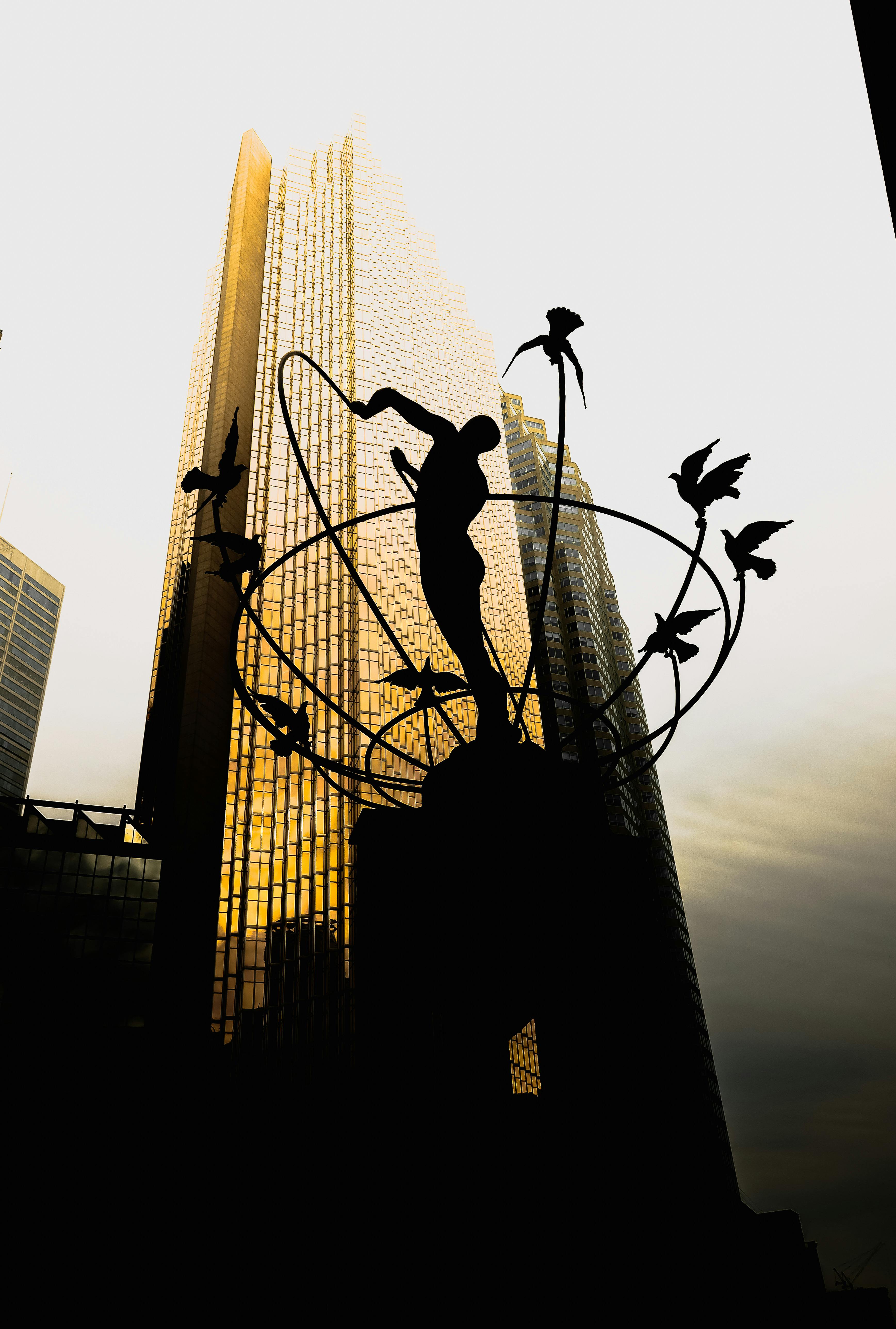 Silhouette of Sculpture with Skyscrapers in Background · Free Stock Photo