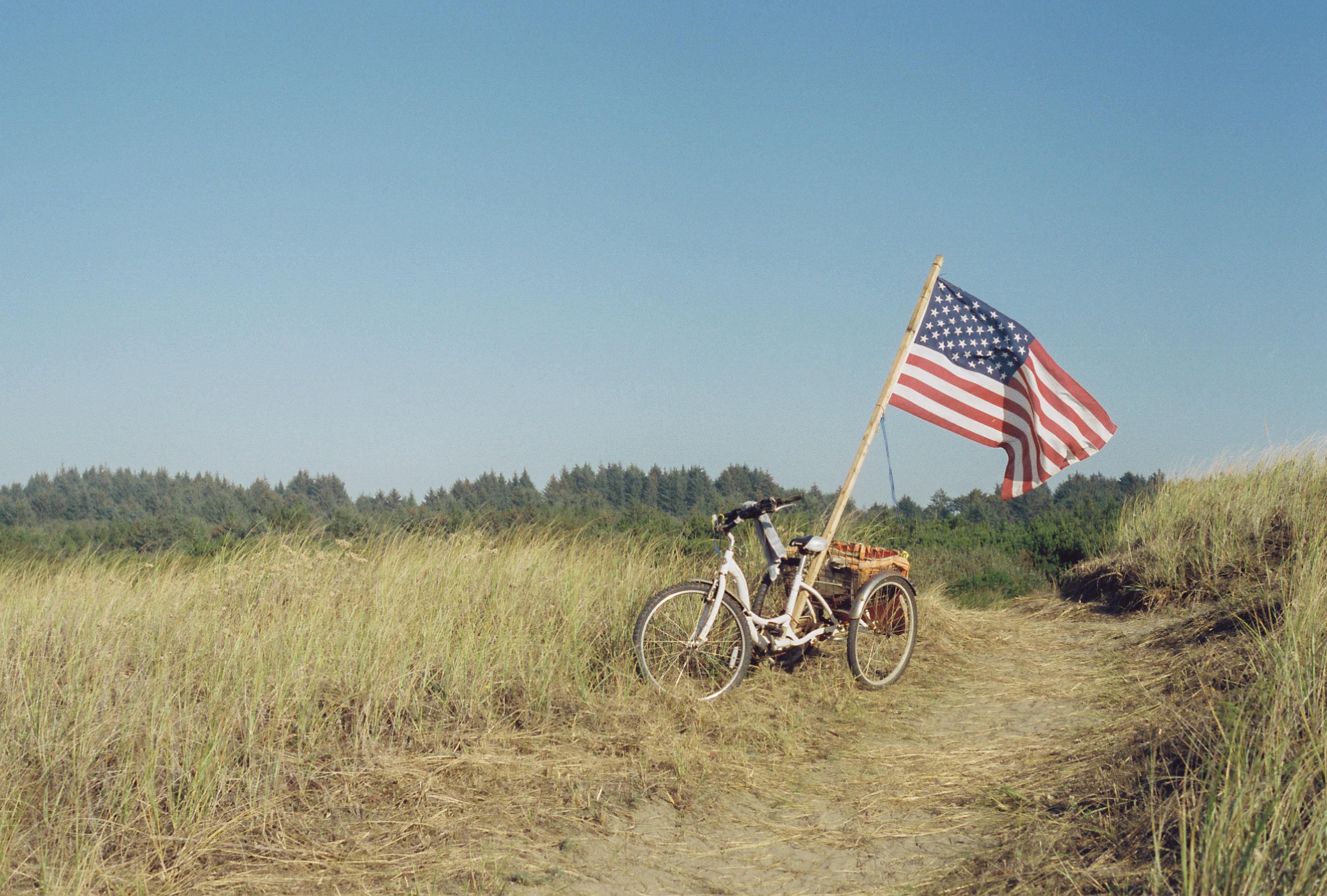 American Flag Set on a Bicycle in a Field · Free Stock Photo
