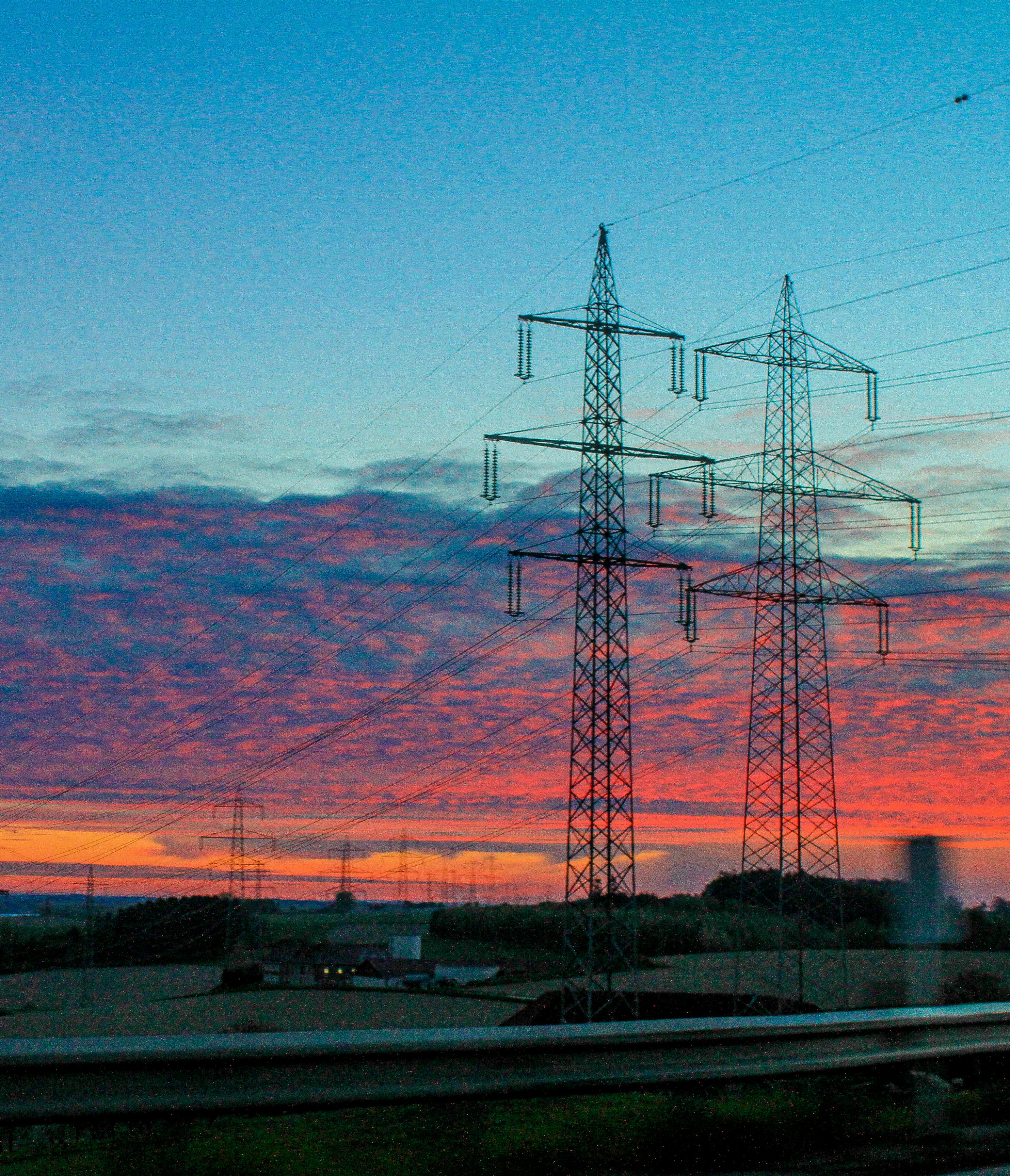 Silhouette of Electric Posts and Power Lines under Gray Sky with Red ...