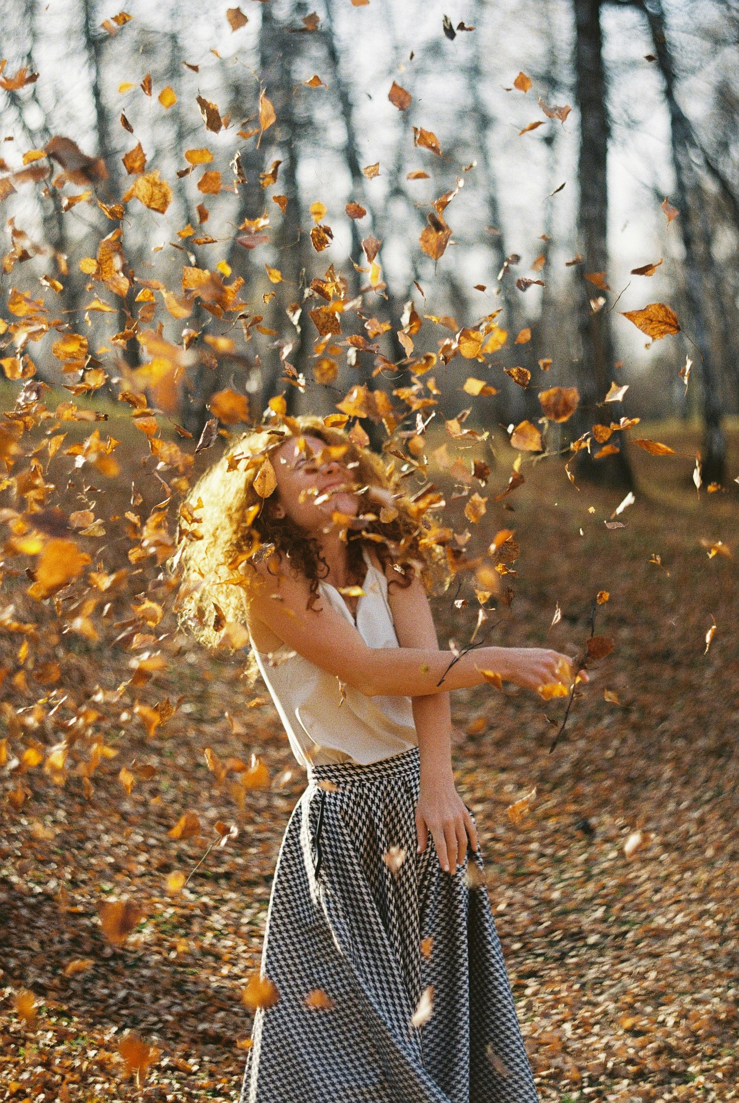 Woman Tossing Autumn Leaves in the Forest and Smiling · Free Stock Photo