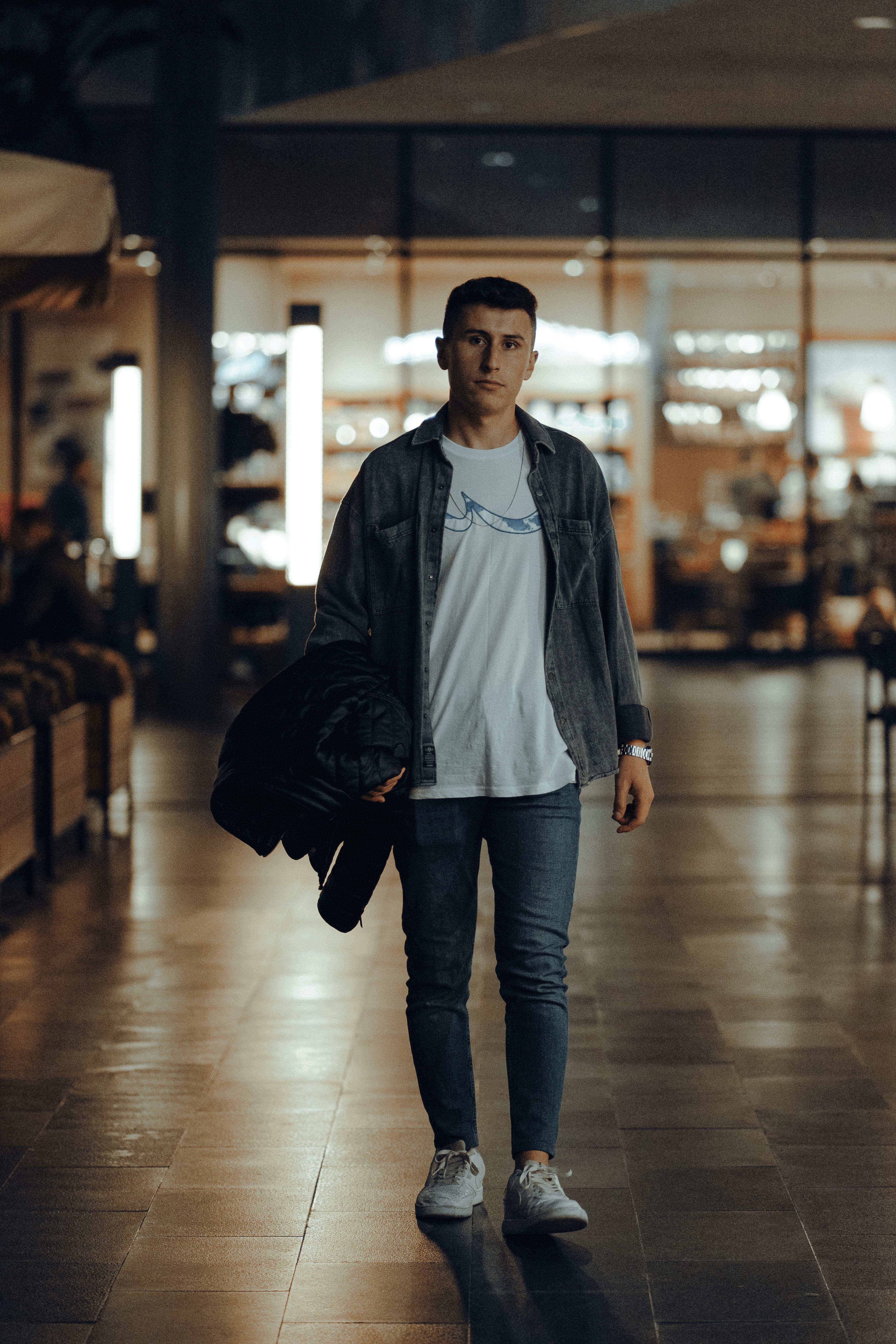 A Man in Black Jacket Walking inside Building · Free Stock Photo