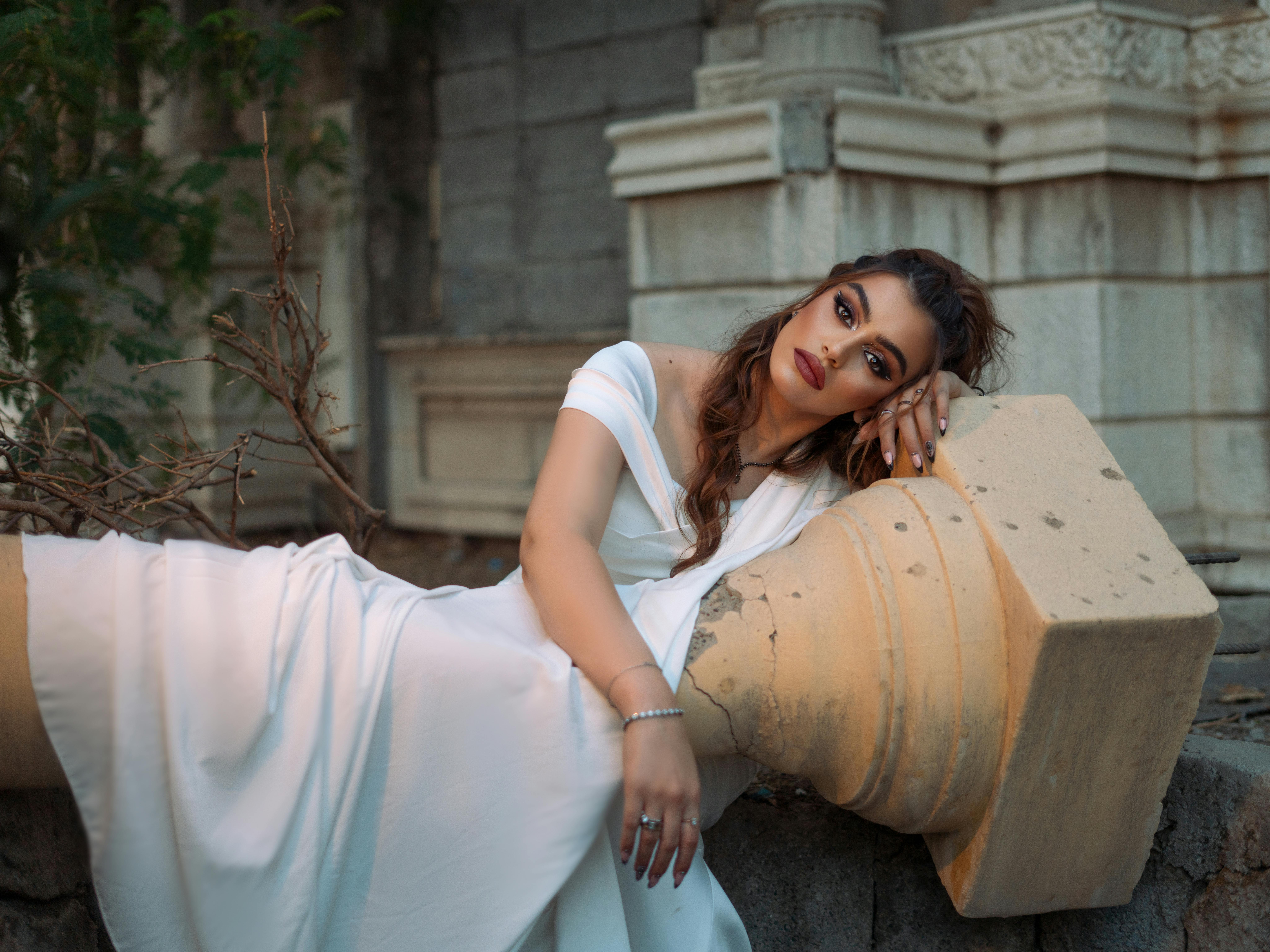 A Pretty Woman in a White Dress Leaning on a Fallen Pillar · Free Stock ...
