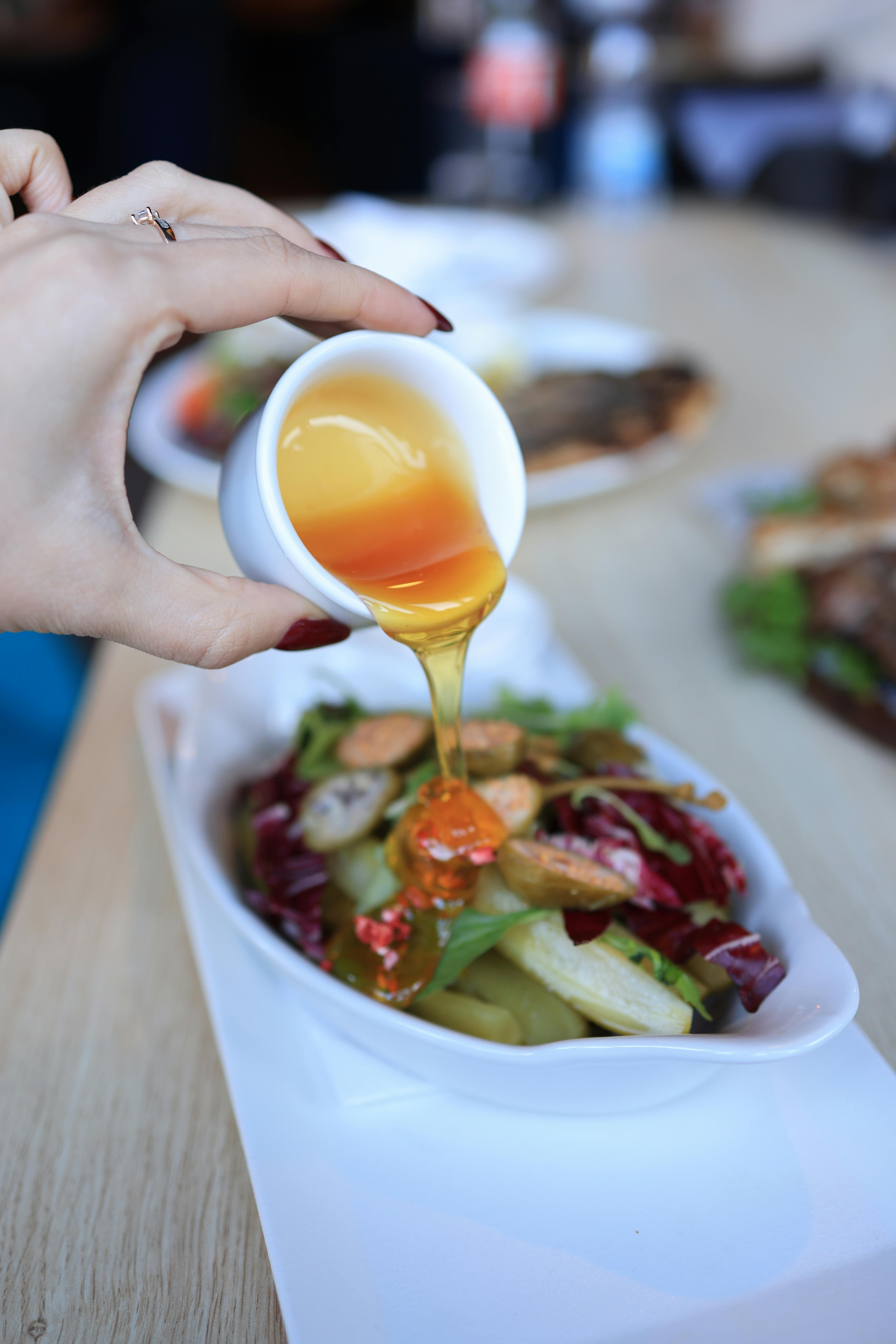 Hand Pouring Sauce of Sandwich · Free Stock Photo