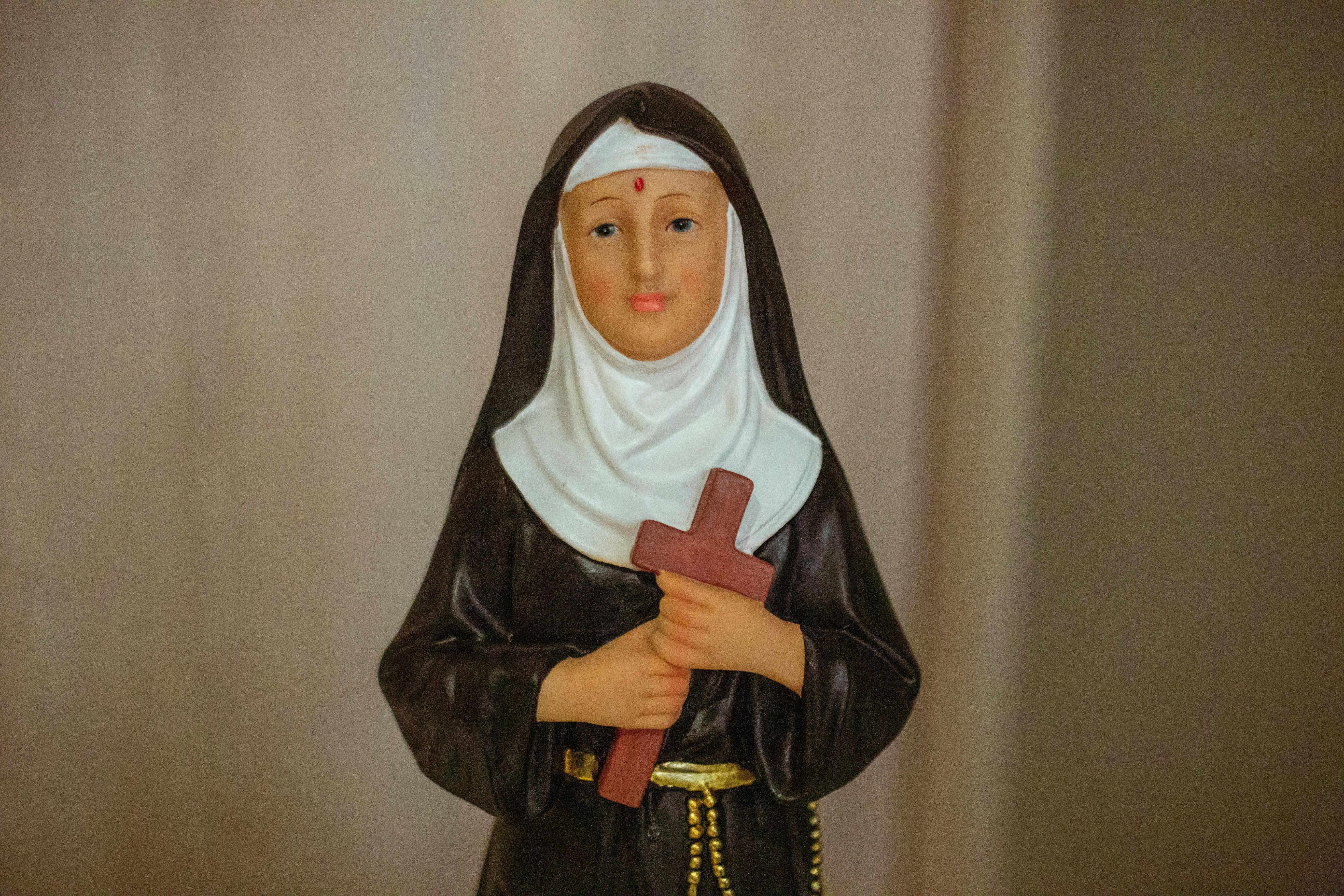 A Sculpture of a Nun Holding a Cross · Free Stock Photo