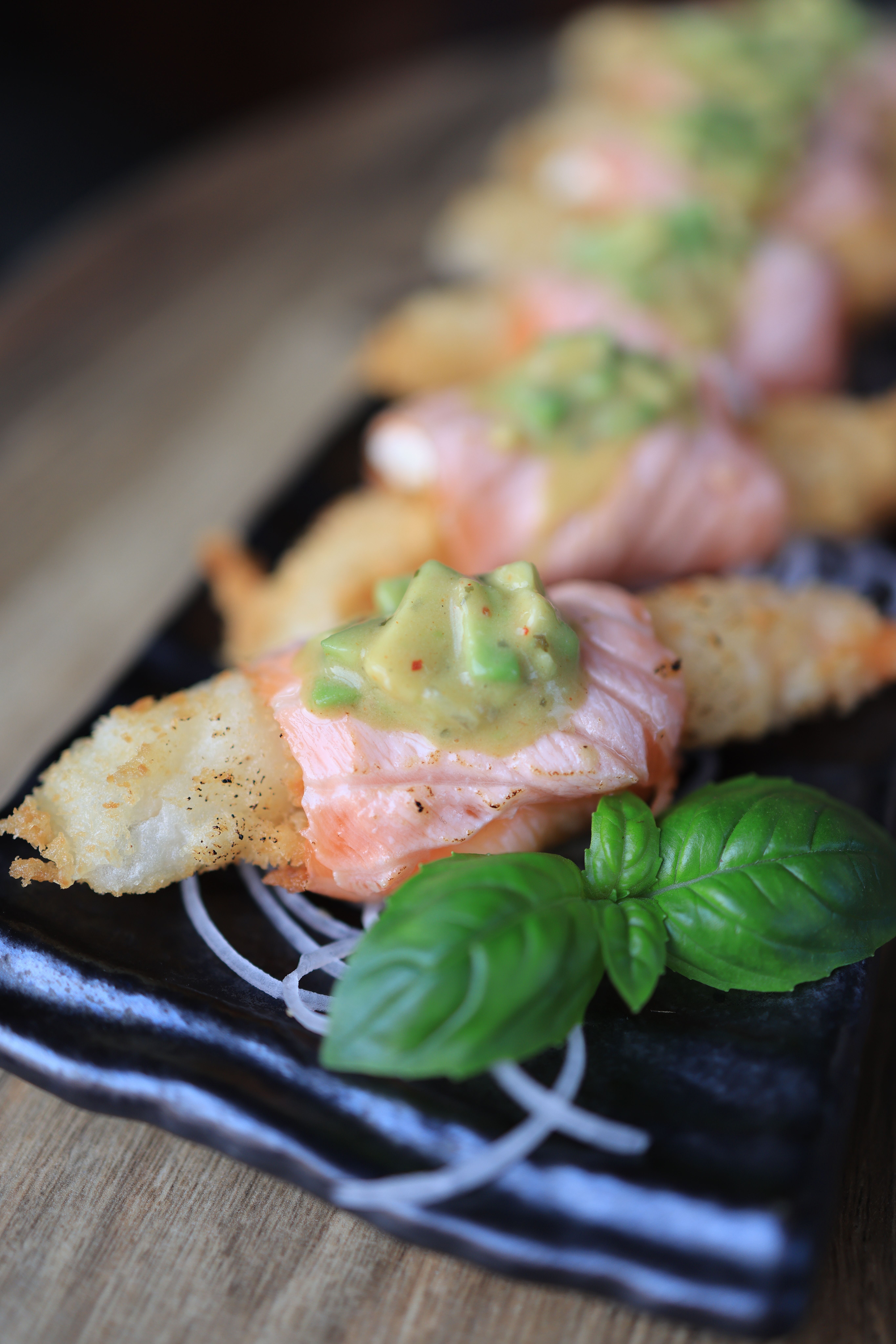 Deep Fried Fish Topped with Salmon and Garnish Served on Black Plate ...