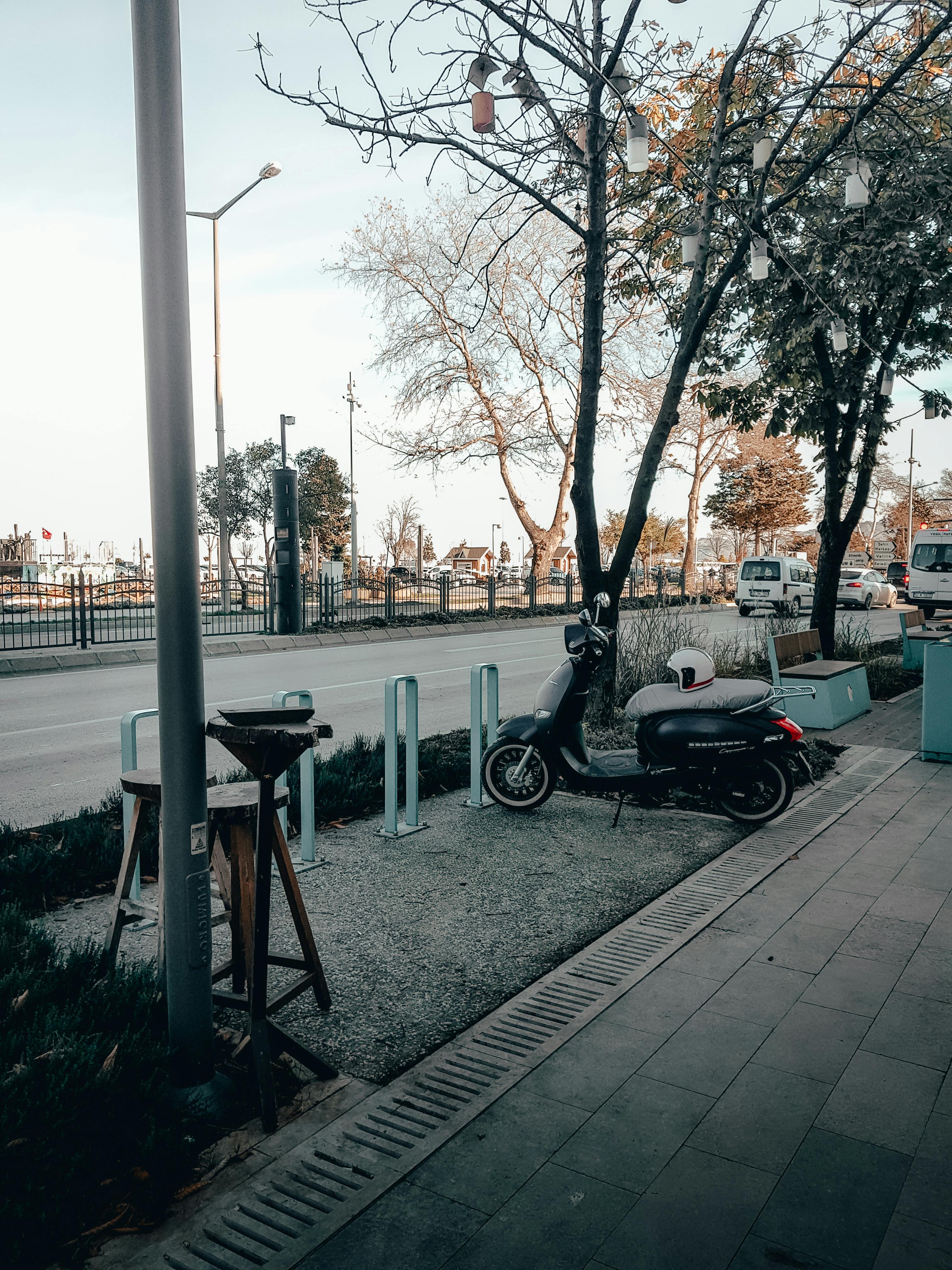 Black Motorcycle Parked on Sidewalk Near Trees · Free Stock Photo