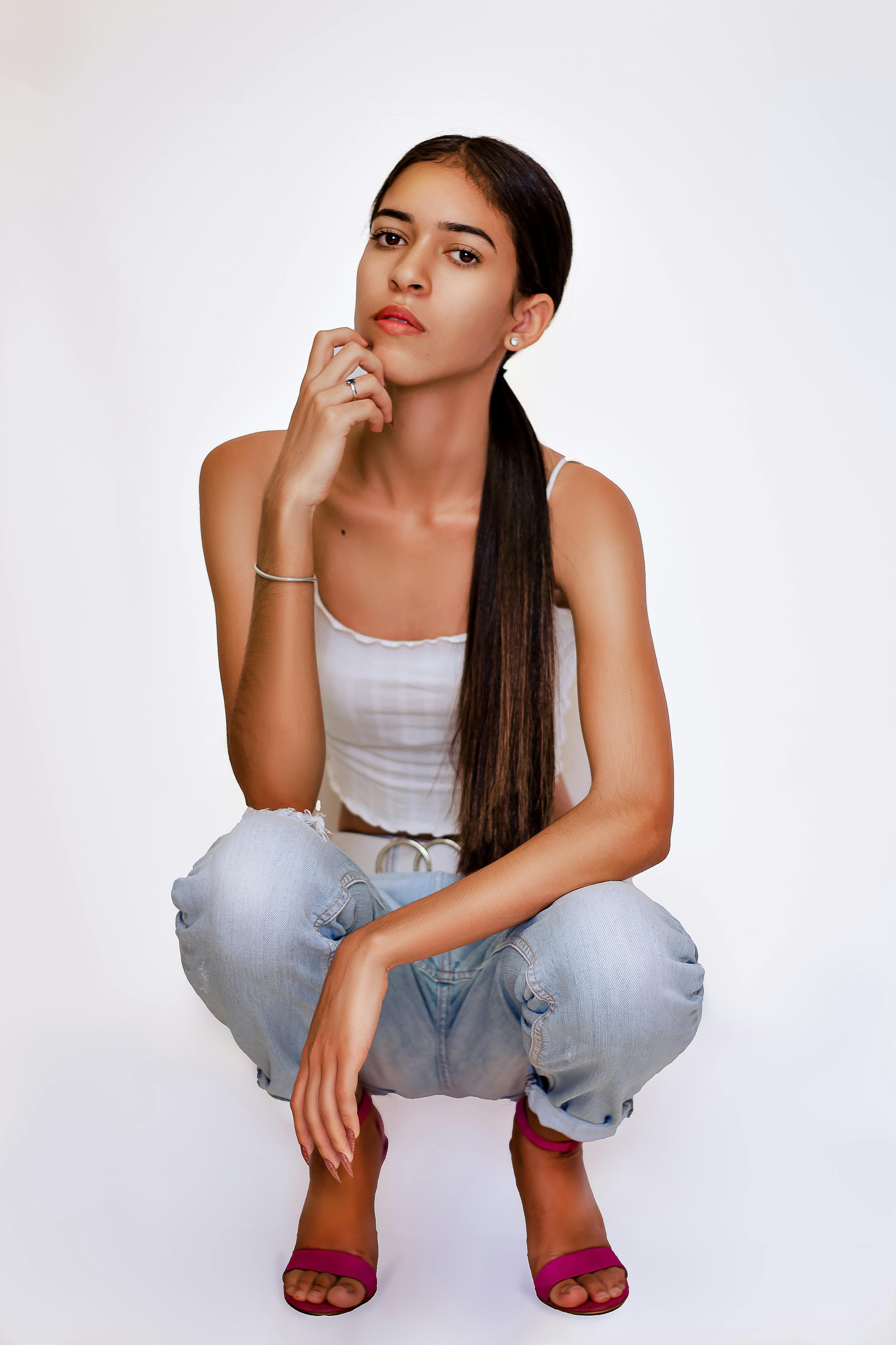Model Crouching in Jeans · Free Stock Photo