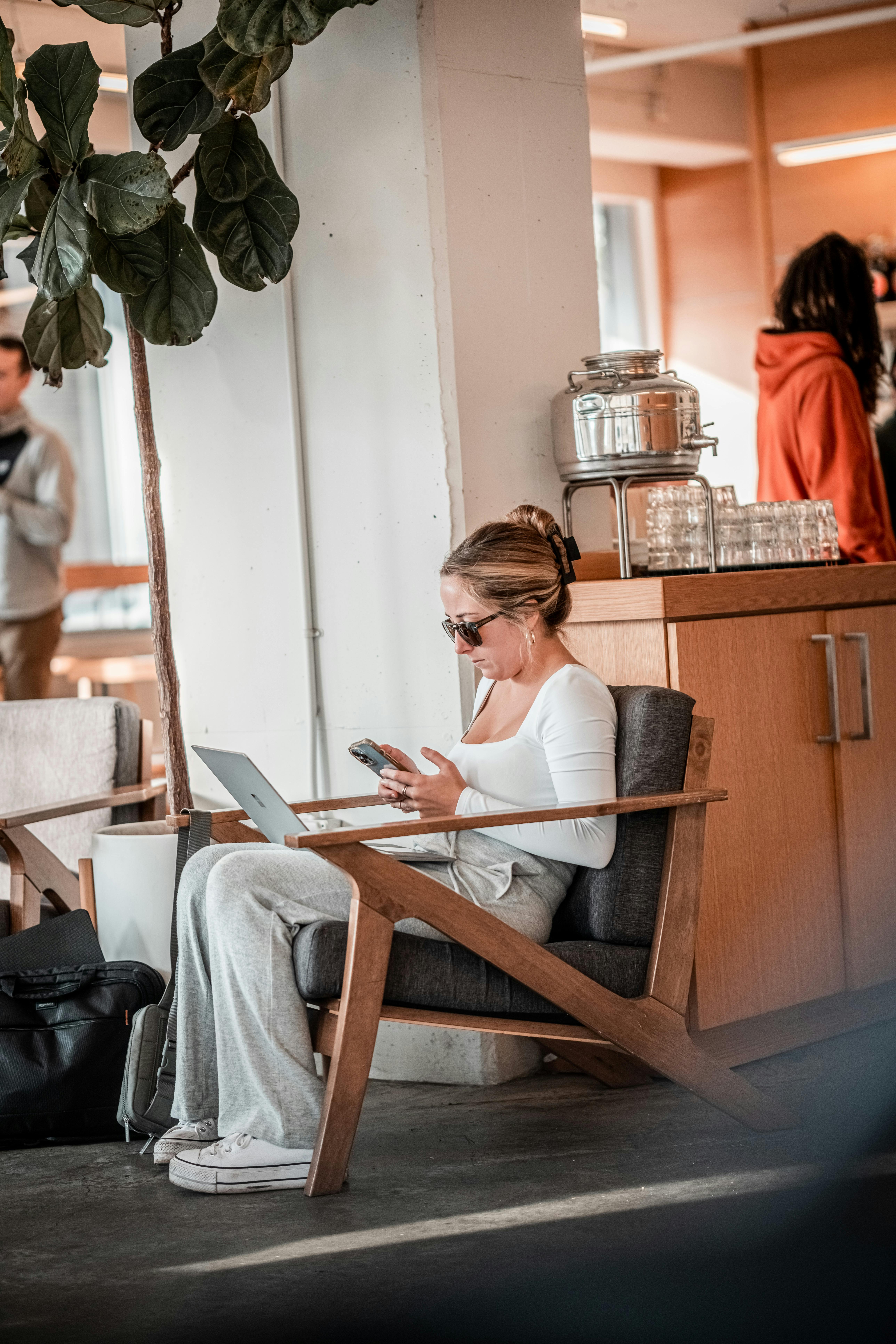 A Woman with Sitting while Using Her Cell Phone · Free Stock Photo