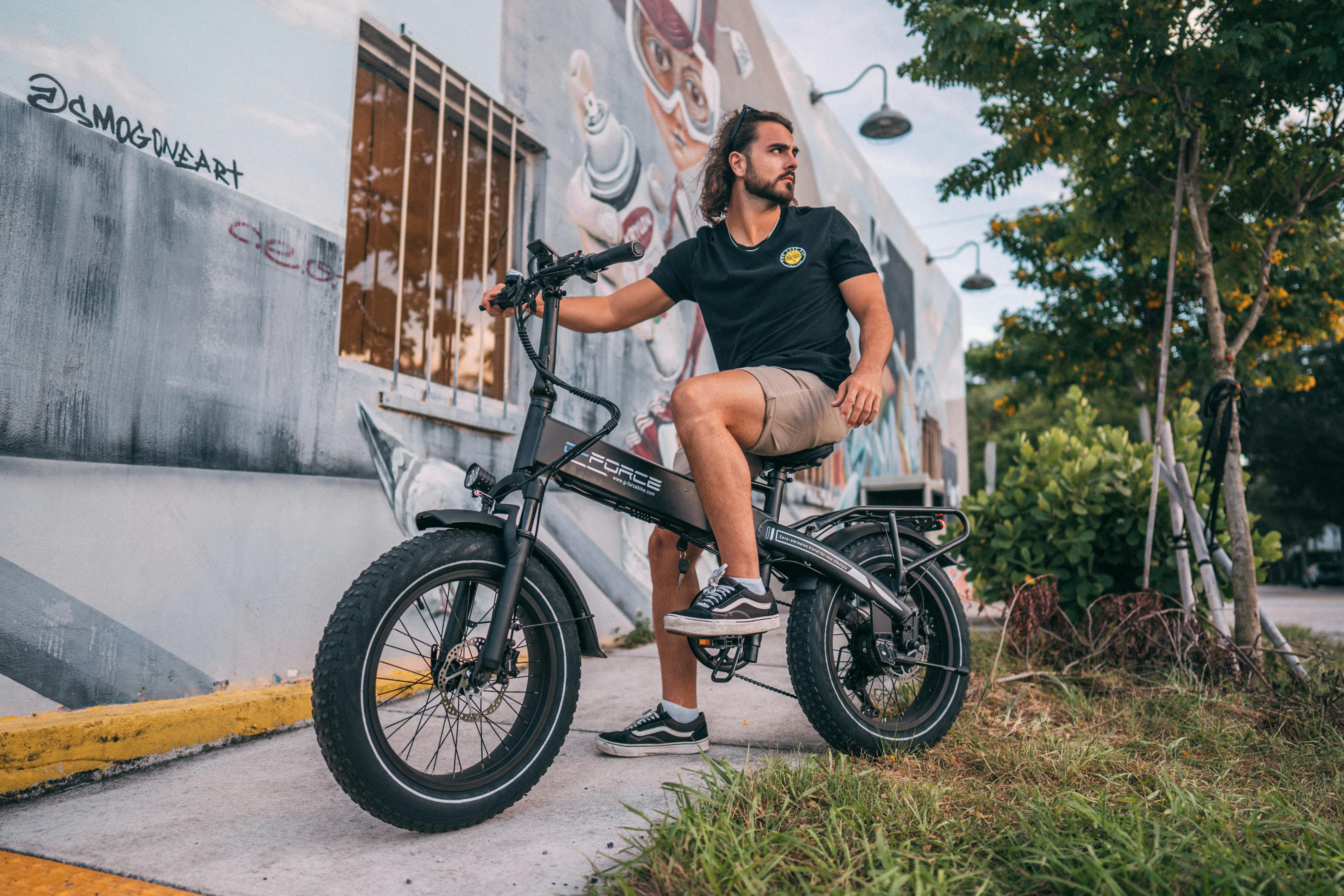 A Man in Black Shirt Riding an Electric Bike on the Street · Free Stock ...