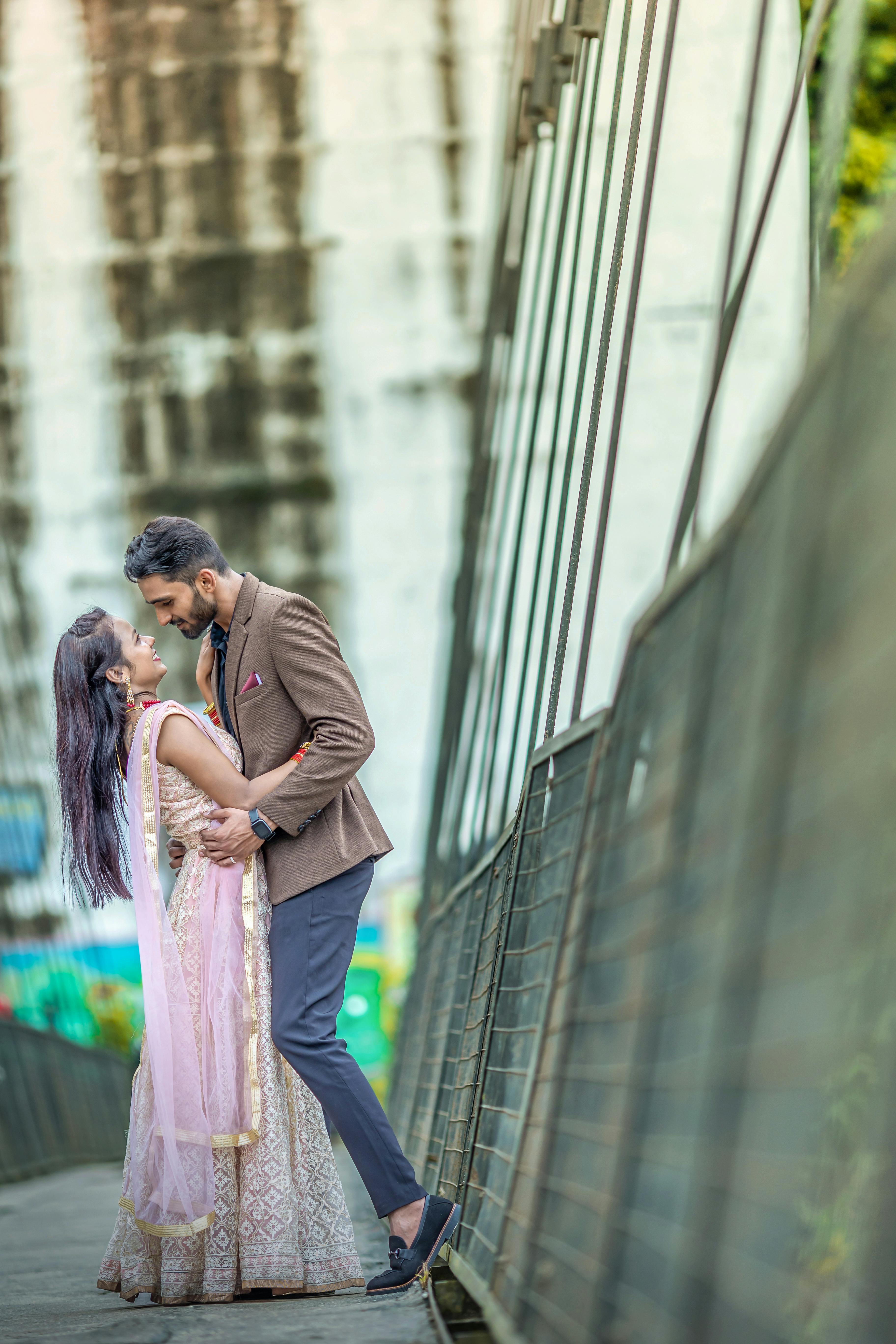 Man Leaning in to Kiss a Woman in a Pink Chiffon Dress · Free Stock Photo