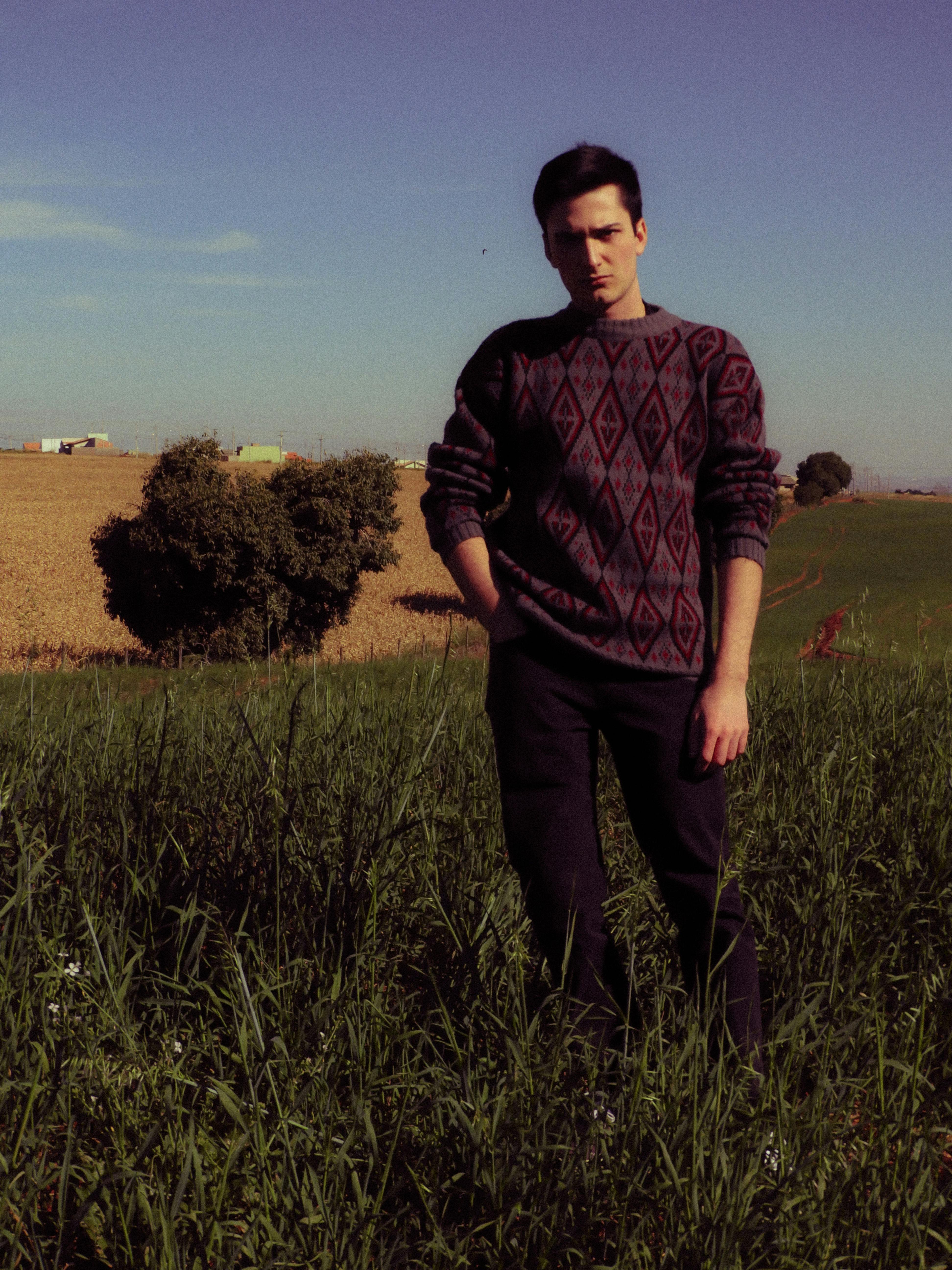 Man Wearing Sweater while Standing on Grass Field · Free Stock Photo