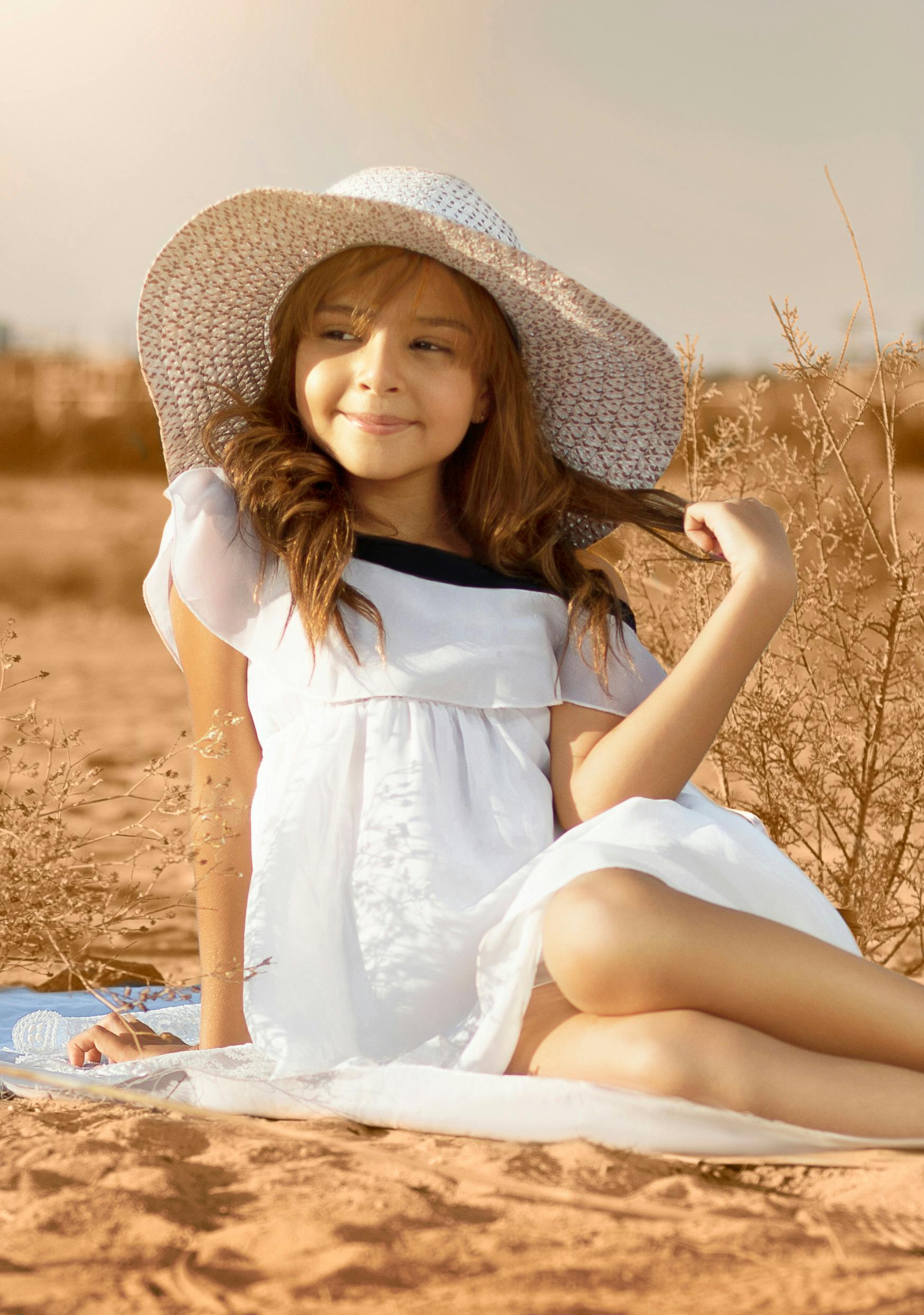 A Girl Modeling in a Sun Hat and White Dress · Free Stock Photo