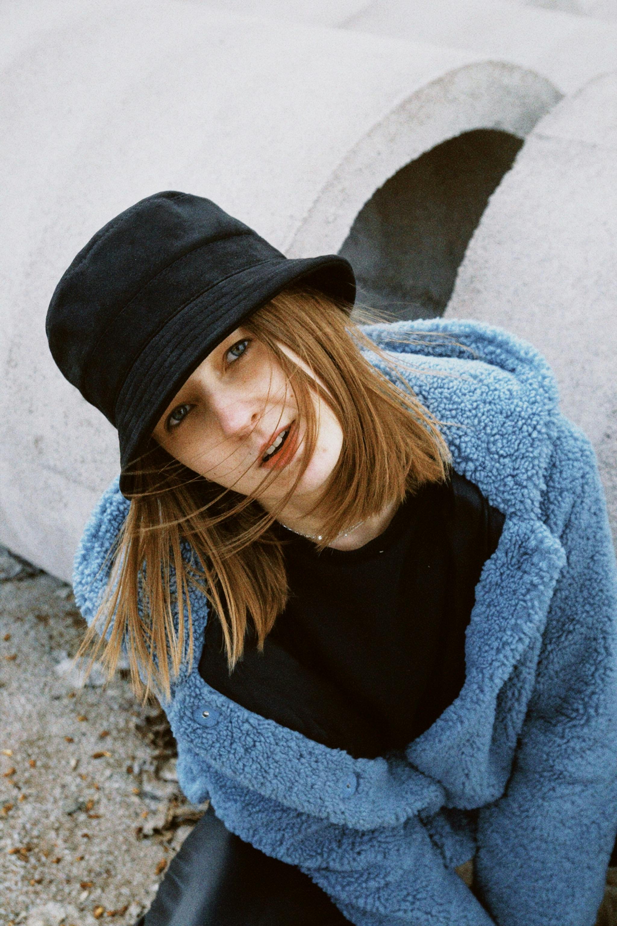 Girl in Bucket Hat Sitting on a Car Hood · Free Stock Photo