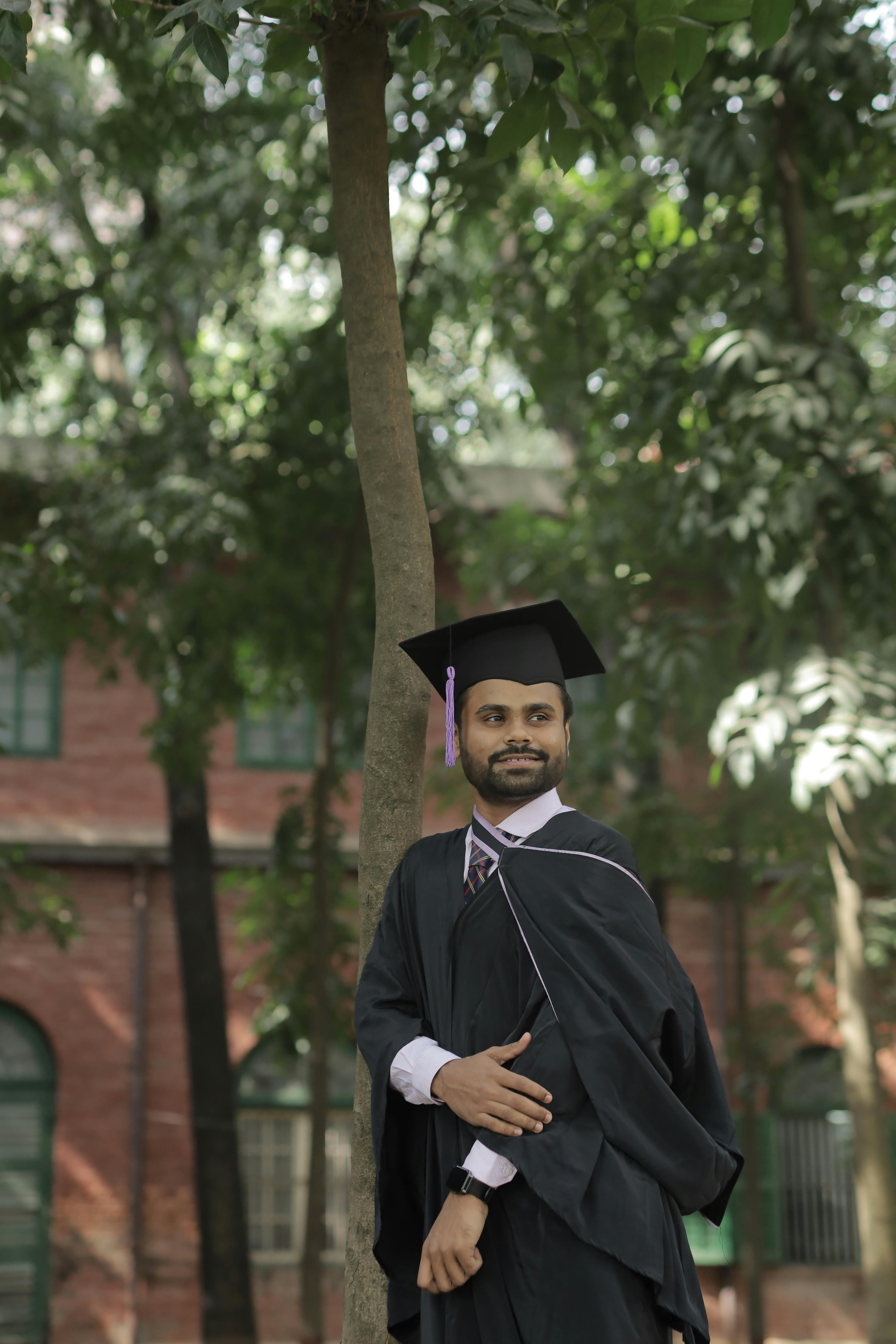 A Man in Black Graduation Gown Smiling at the Camera · Free Stock Photo