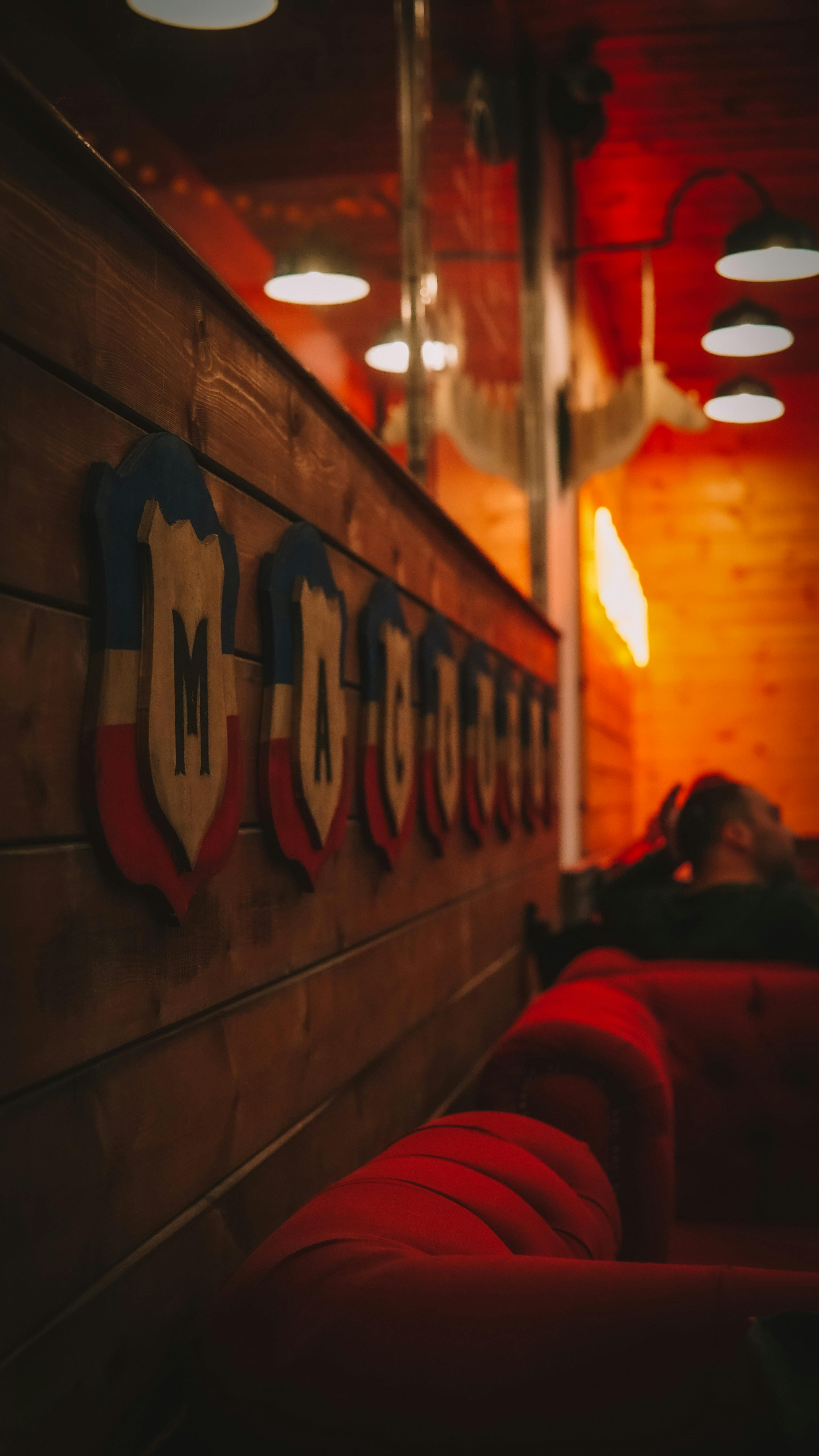 Pub Interior with Red Coaches and Dim Lights · Free Stock Photo