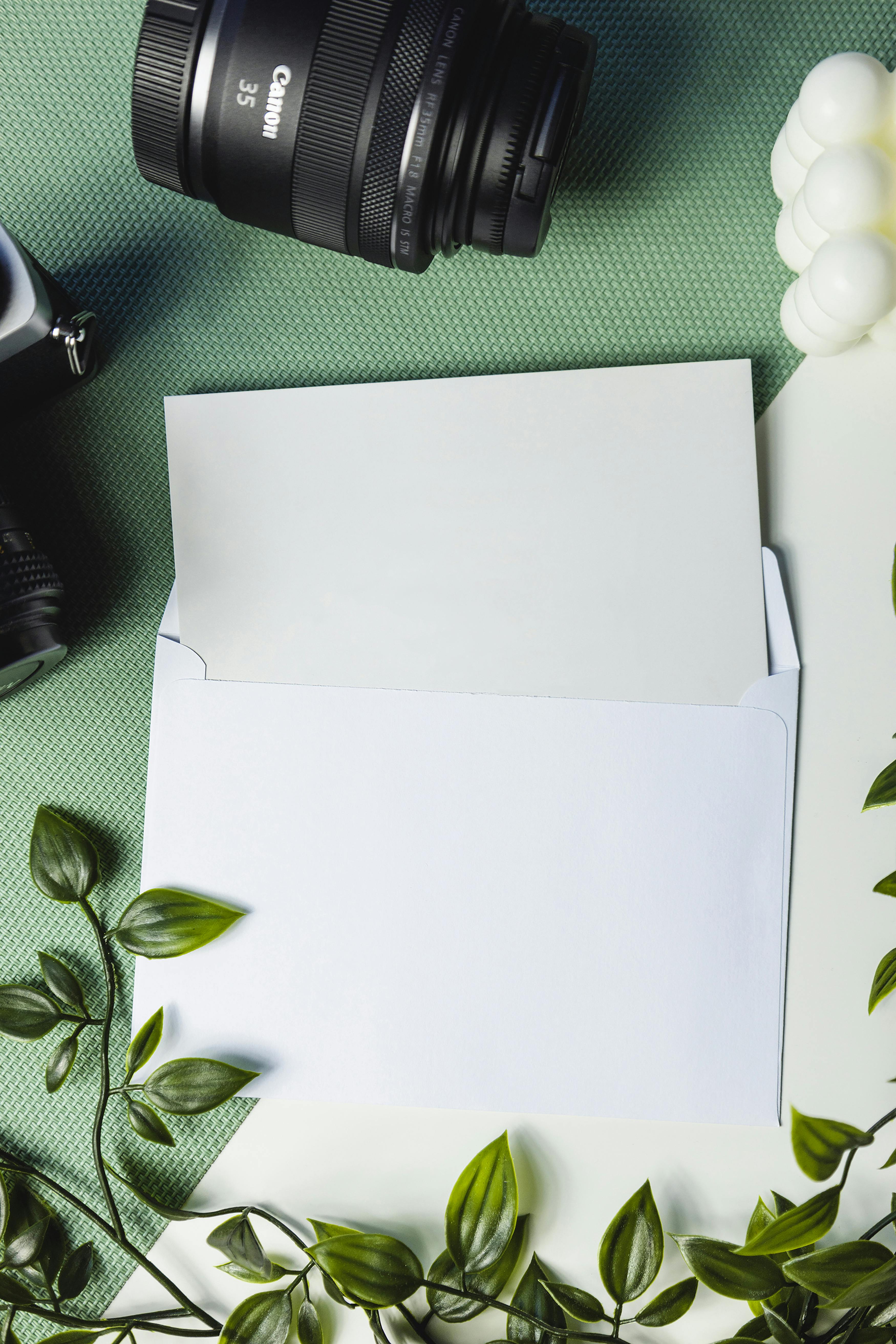 Open Envelope with a Blank Card in it and a Camera · Free Stock Photo