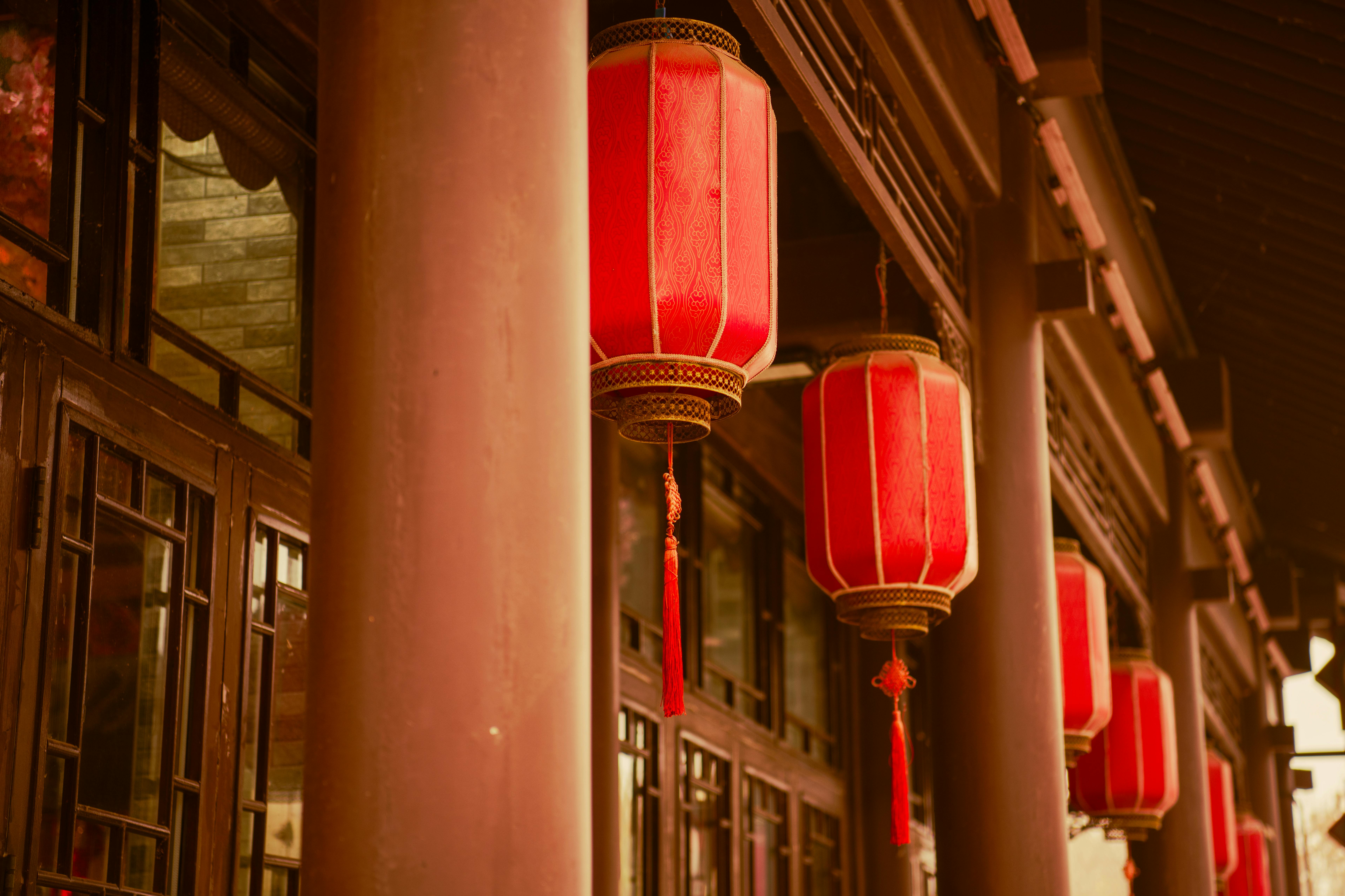 Red Lanterns Hanging Between Columns · Free Stock Photo
