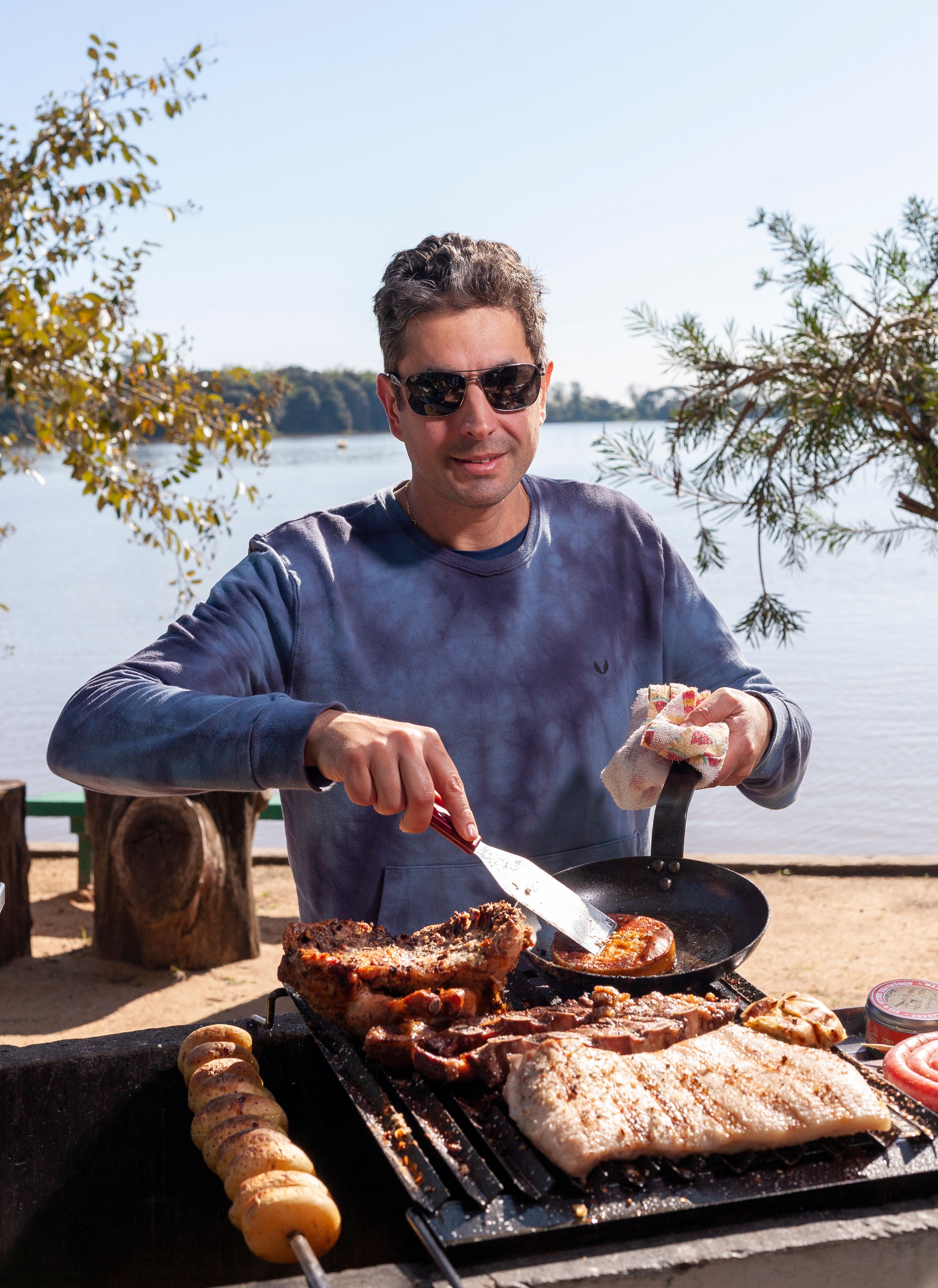 Man in Blue Long Sleeve Shirt Cooking a Meat · Free Stock Photo