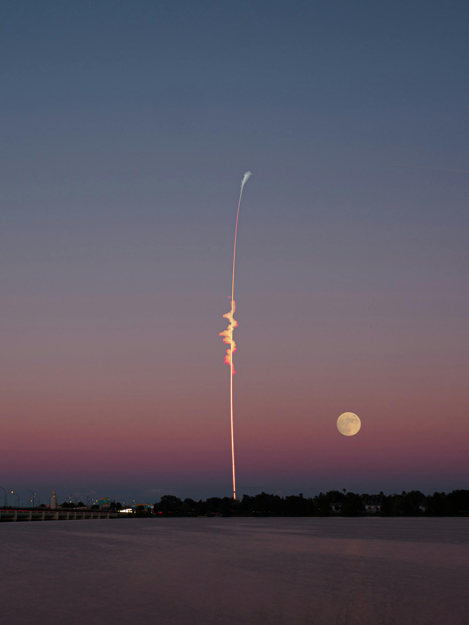 Rocketship Leaving a Trail over a Rising Moon at Dusk · Free Stock Photo