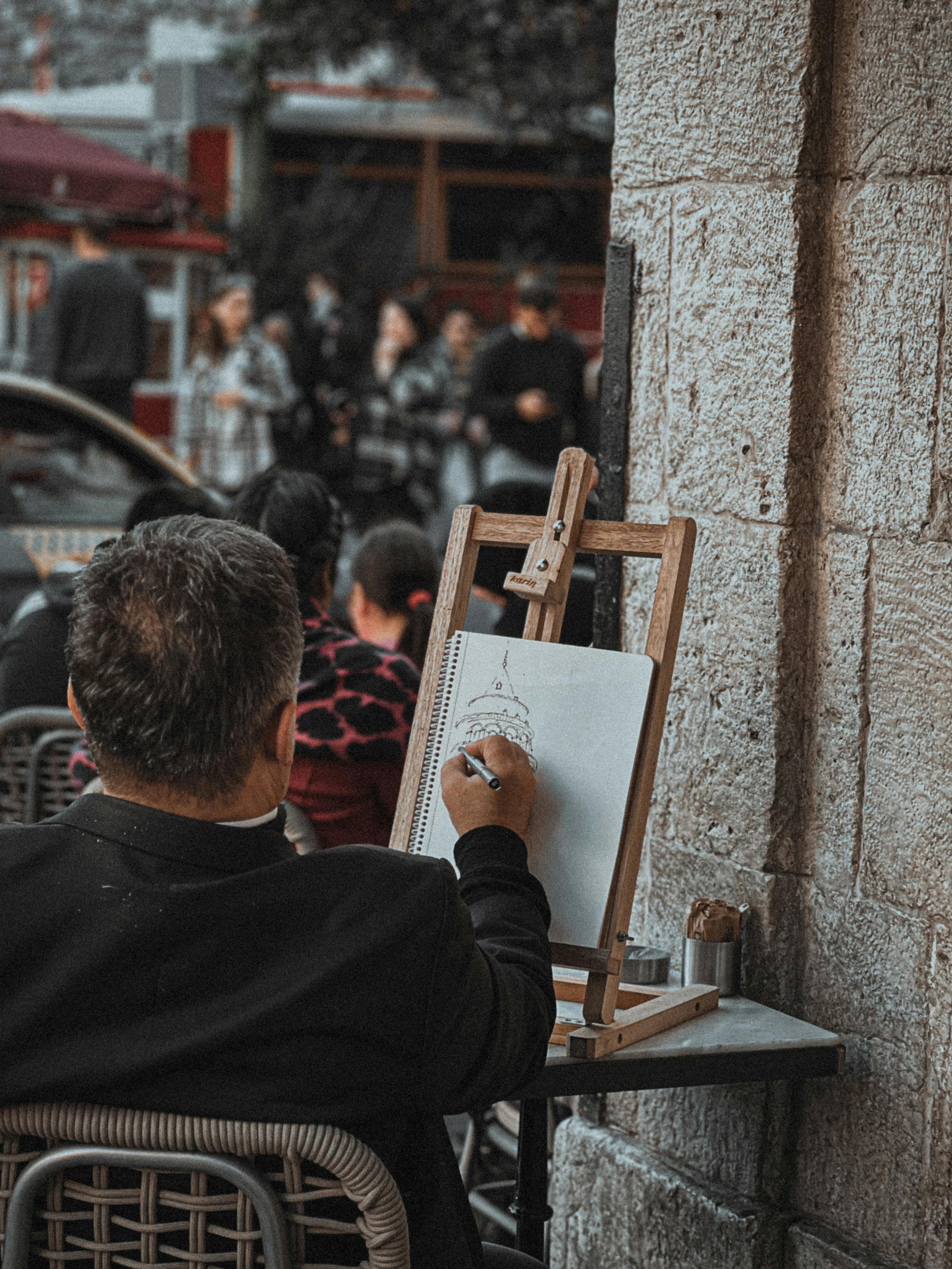 A Man Drawing on Paper · Free Stock Photo